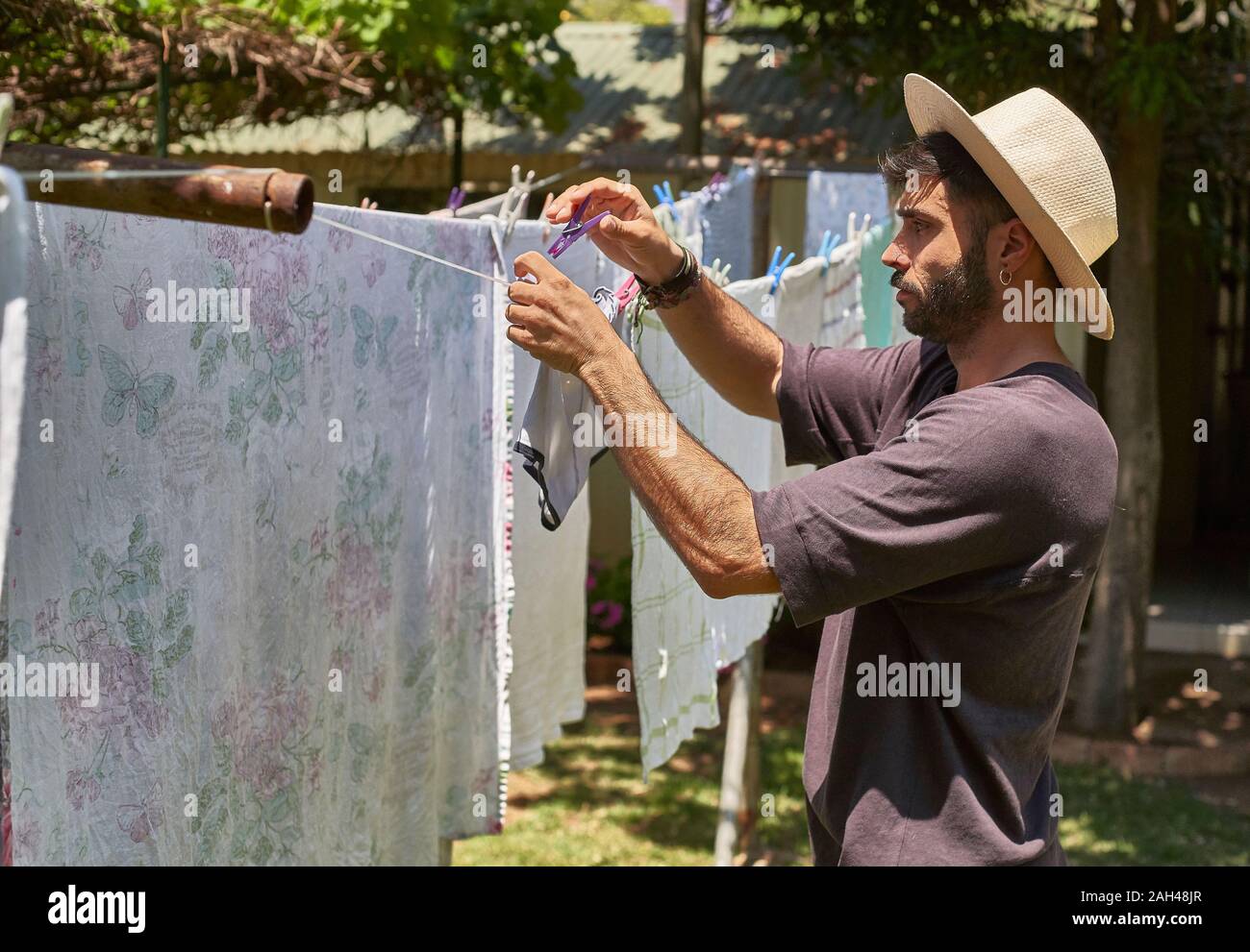 Man hanging up laundry outdoors Stock Photo - Alamy