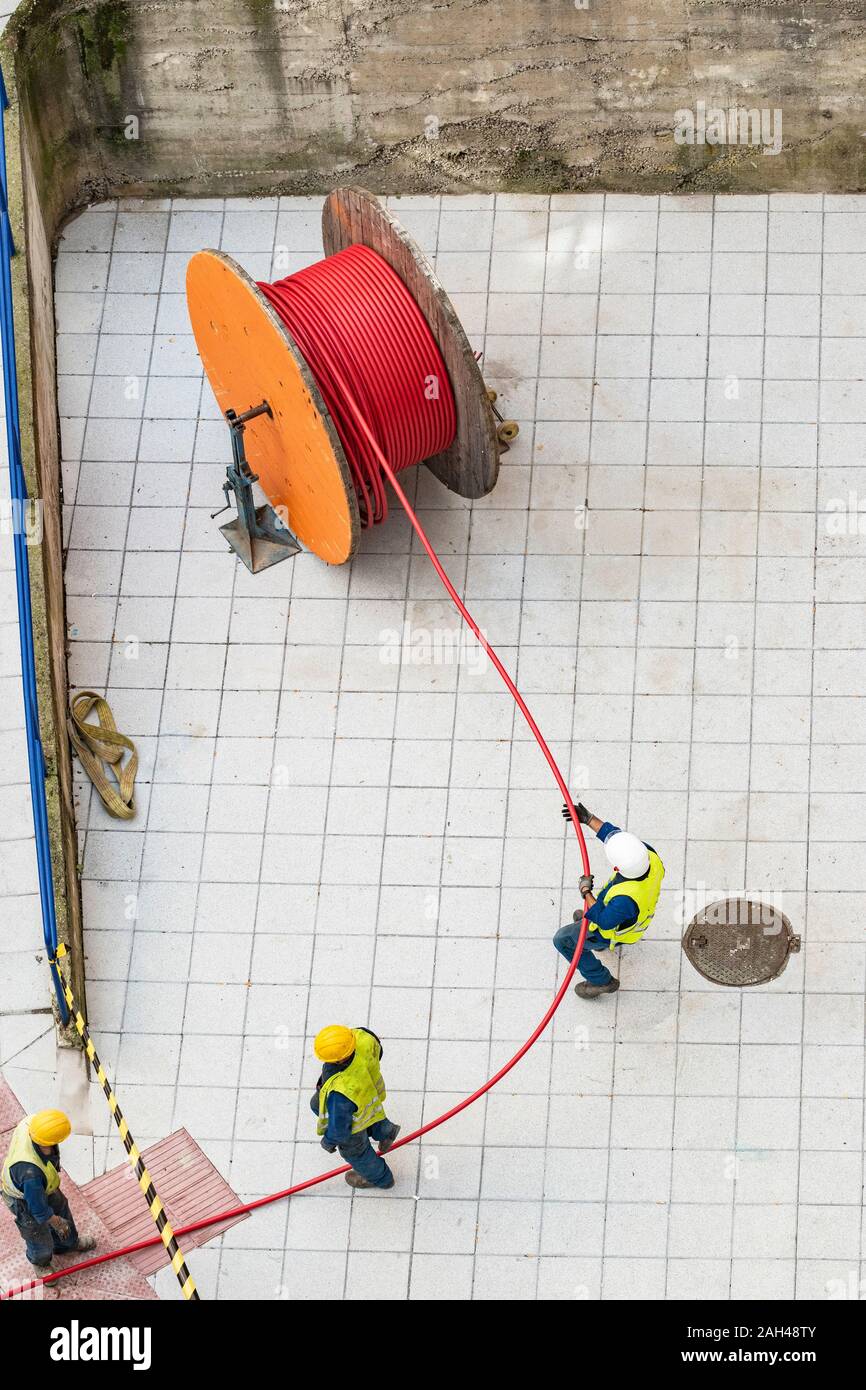 workers using cable to install the electricity Stock Photo - Alamy
