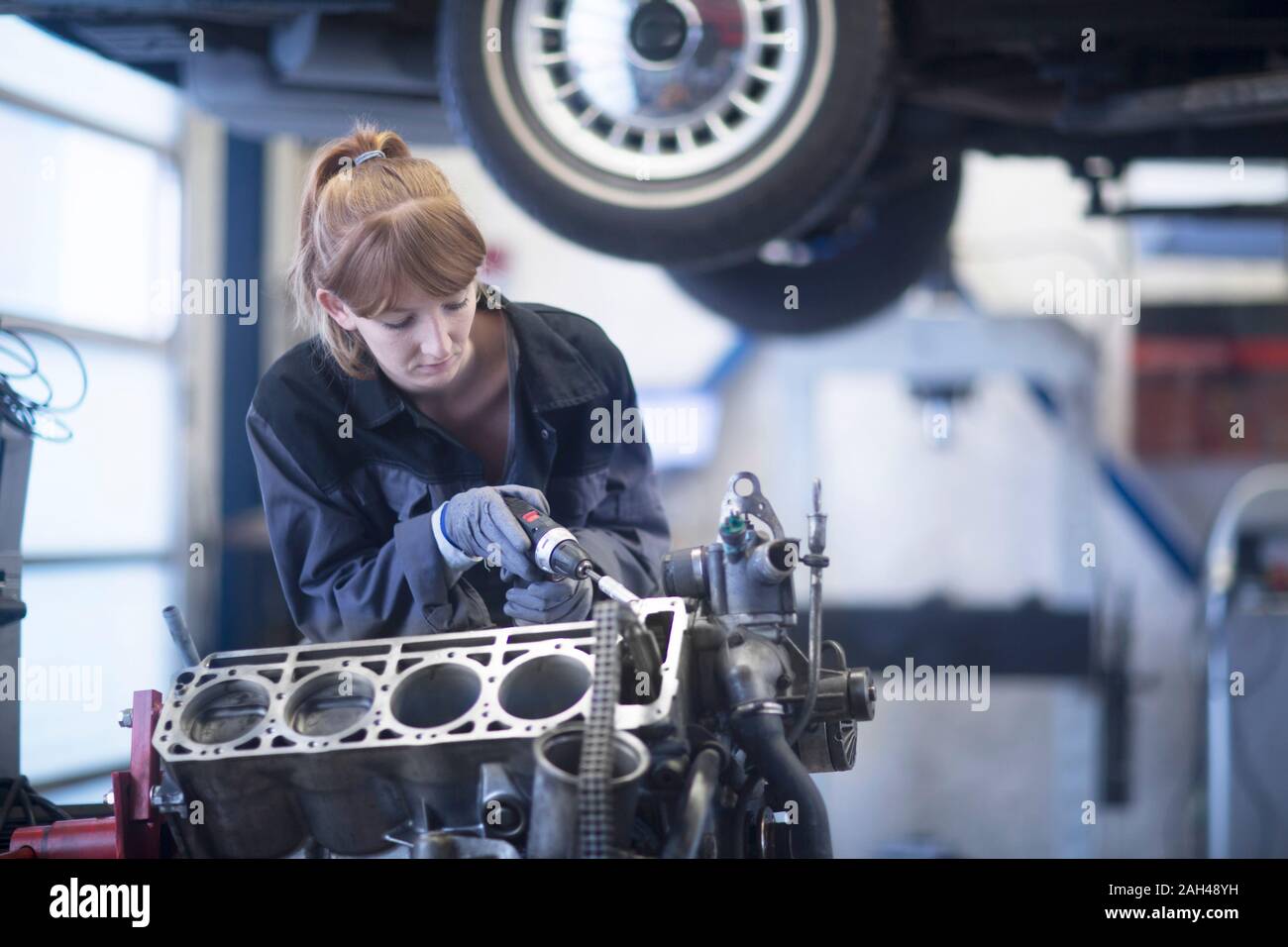 Female car mechanic fixing car in repair garage Stock Photo - Alamy