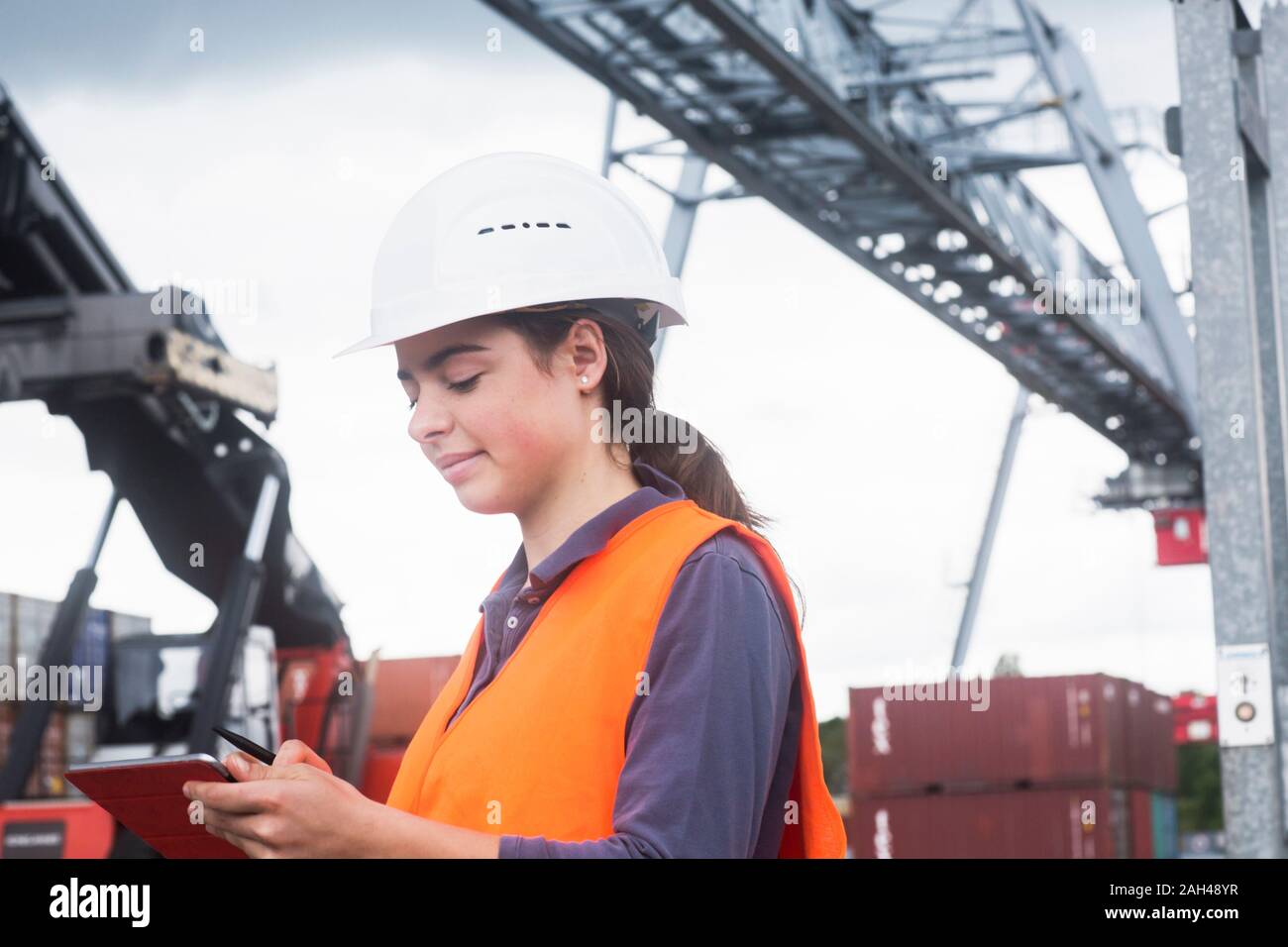 Female worker with clipboard taking notes on industrial site Stock ...