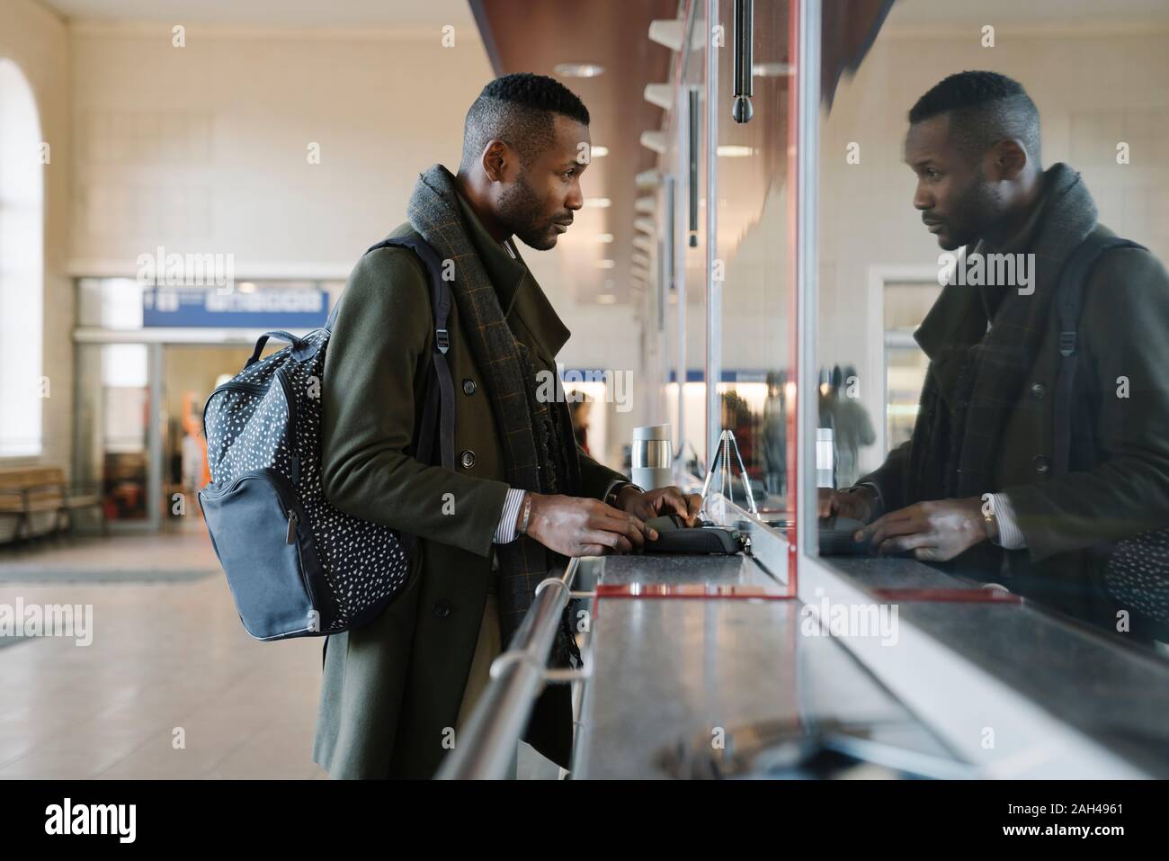 Stylish man buying ticket in train station Stock Photo - Alamy