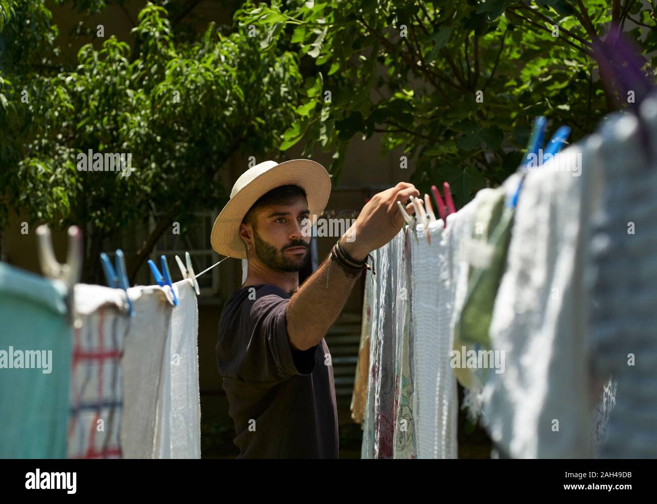 Man hanging up laundry outdoors Stock Photo - Alamy