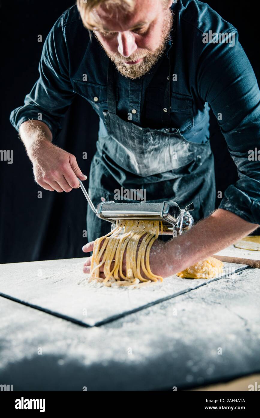 Hobby chef making fresh tagliatelle with pasta machine Stock Photo - Alamy