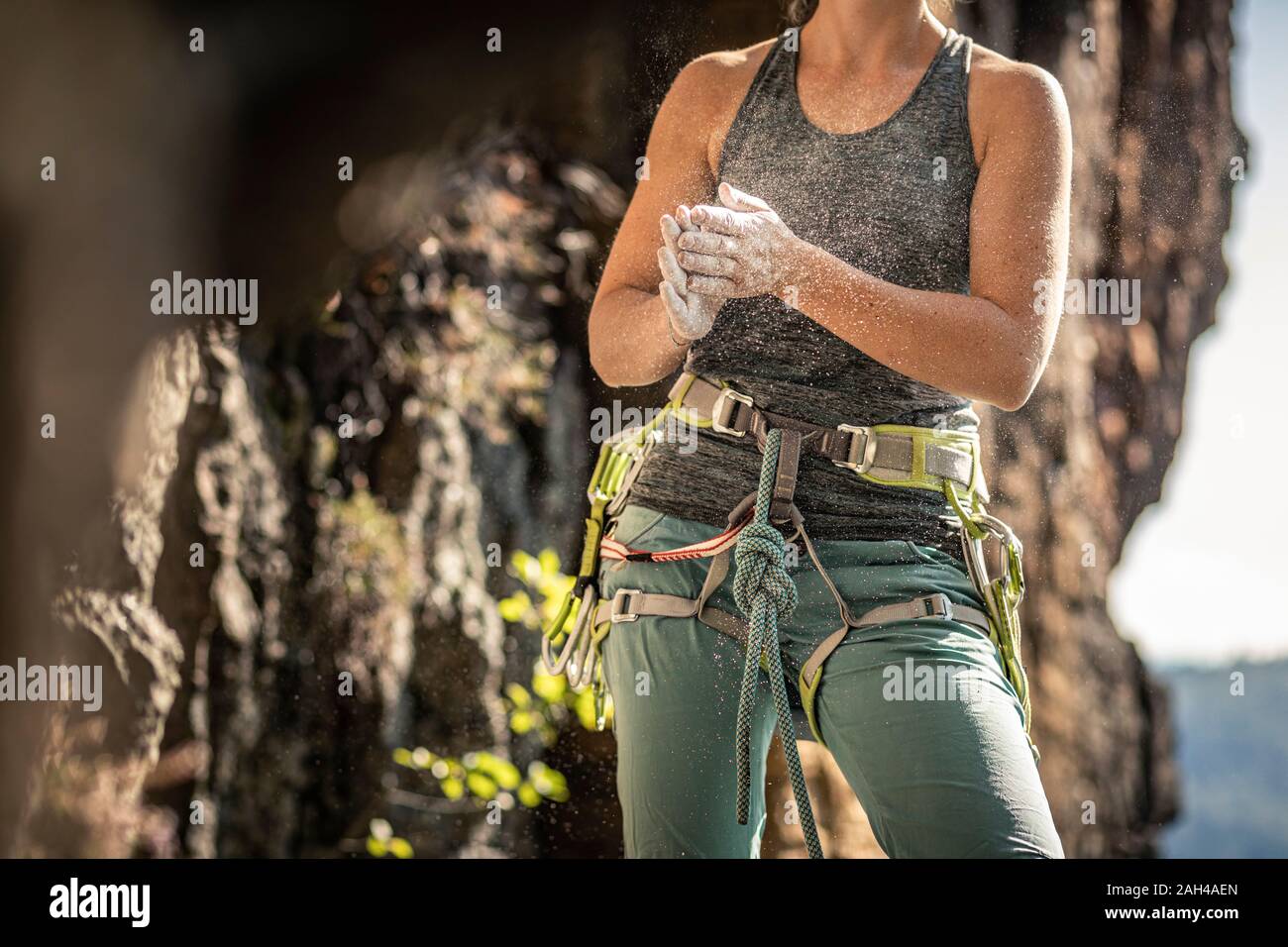 Woman preparing to climb, using chalk powder Stock Photo - Alamy