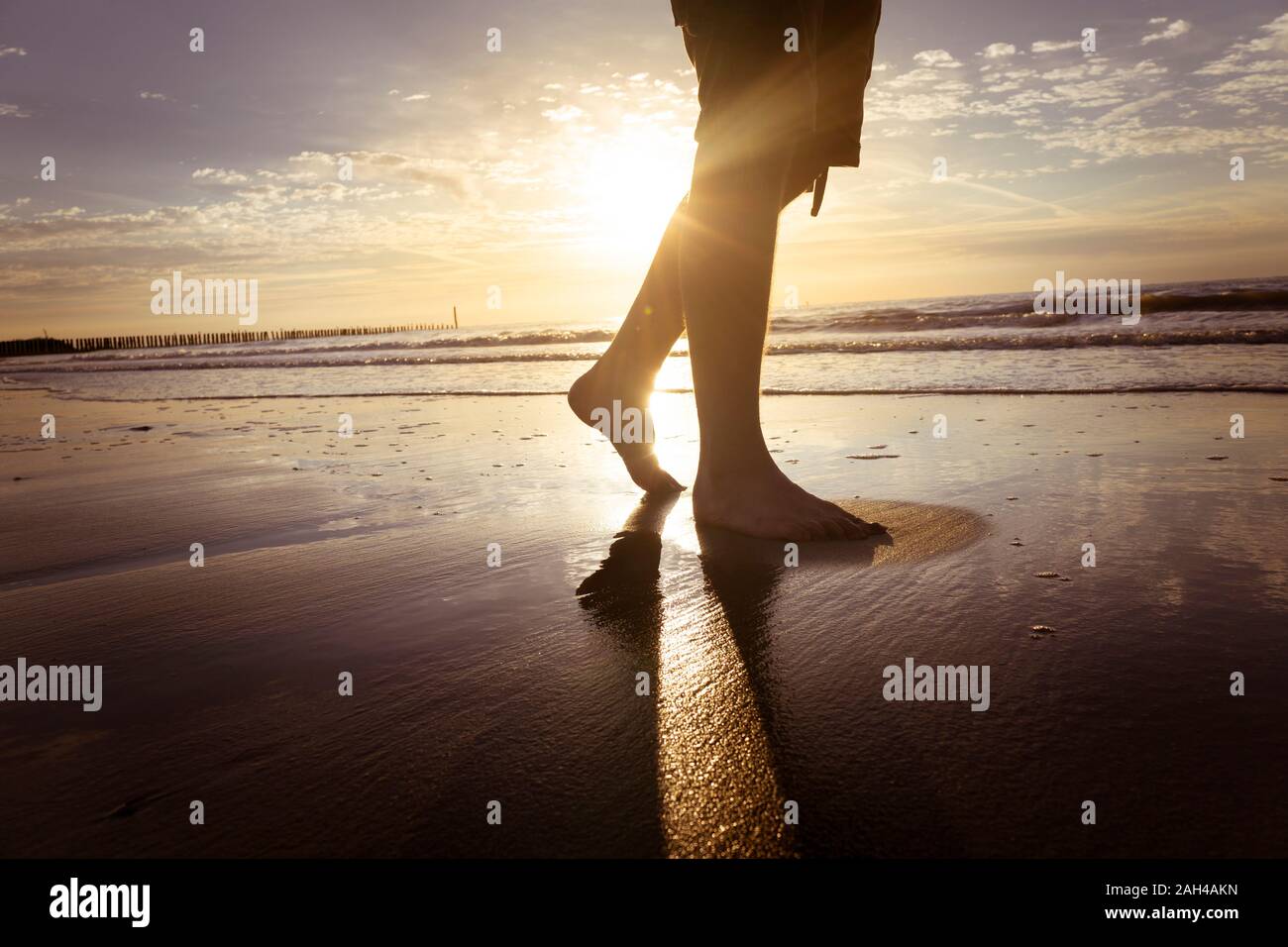Netherlands, Cadzand-Bad, legs of teenage boy walking on the beach at ...