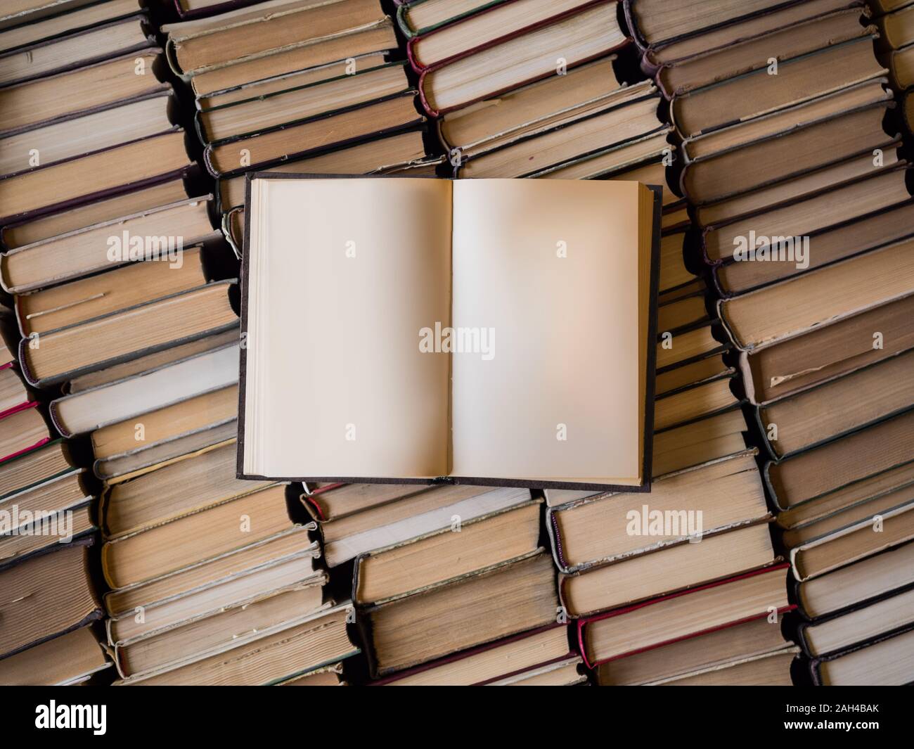 Top view of an opened book over lot of books. Wisdom and knowledge ...