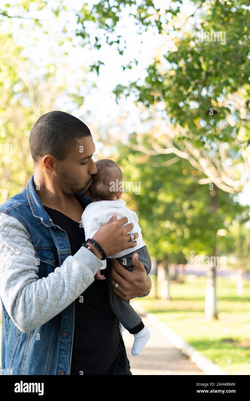 Father carrying his baby son in the park Stock Photo - Alamy