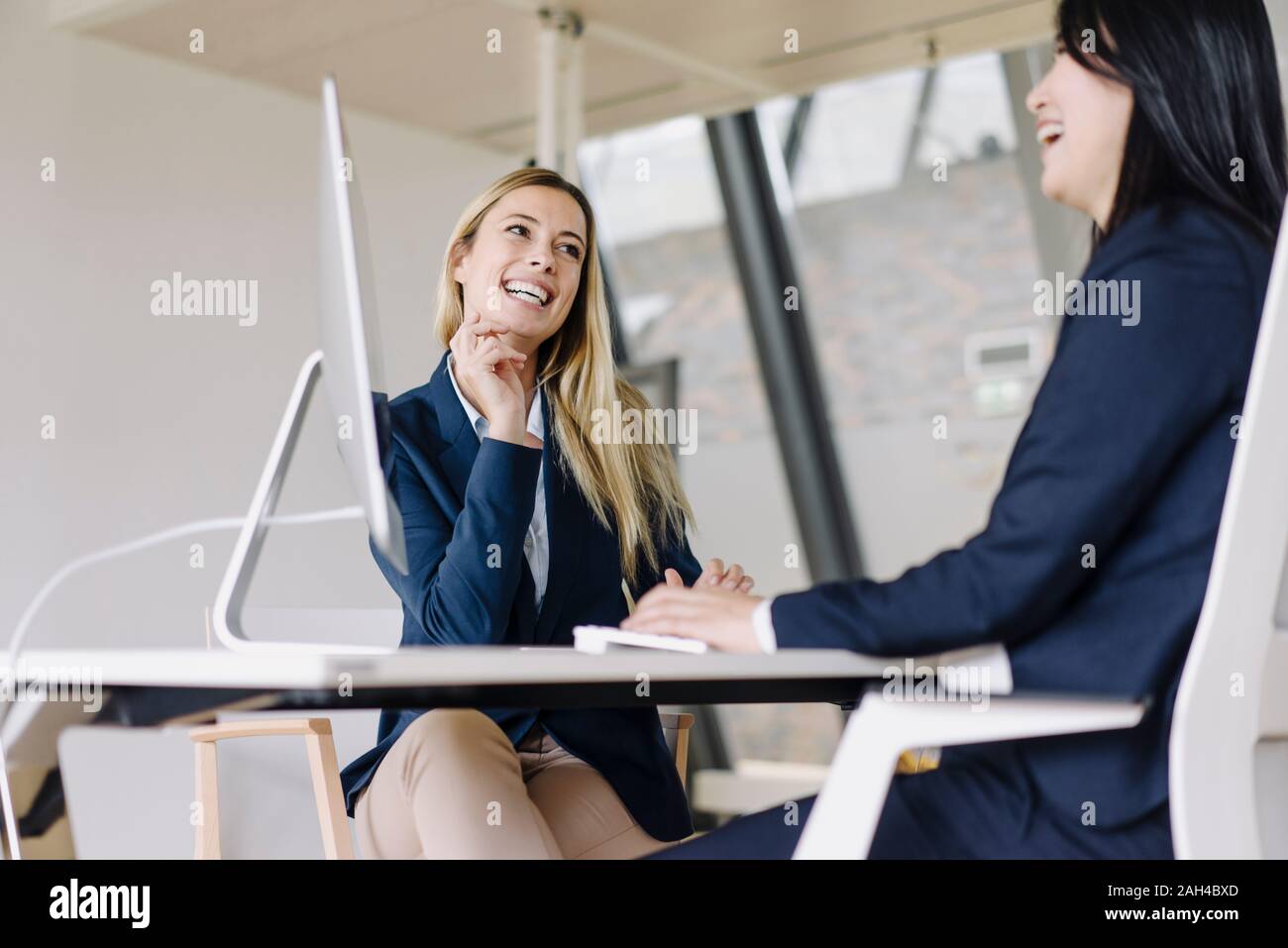 Happy female boss sitting desk hi-res stock photography and images - Alamy