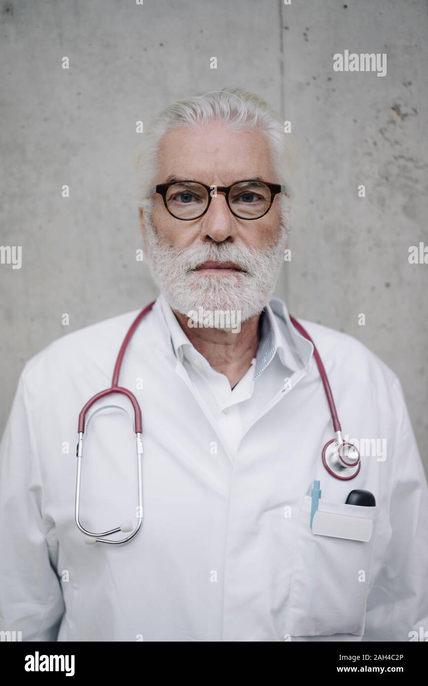 Portrait of a serious doctor at a concrete wall Stock Photo - Alamy
