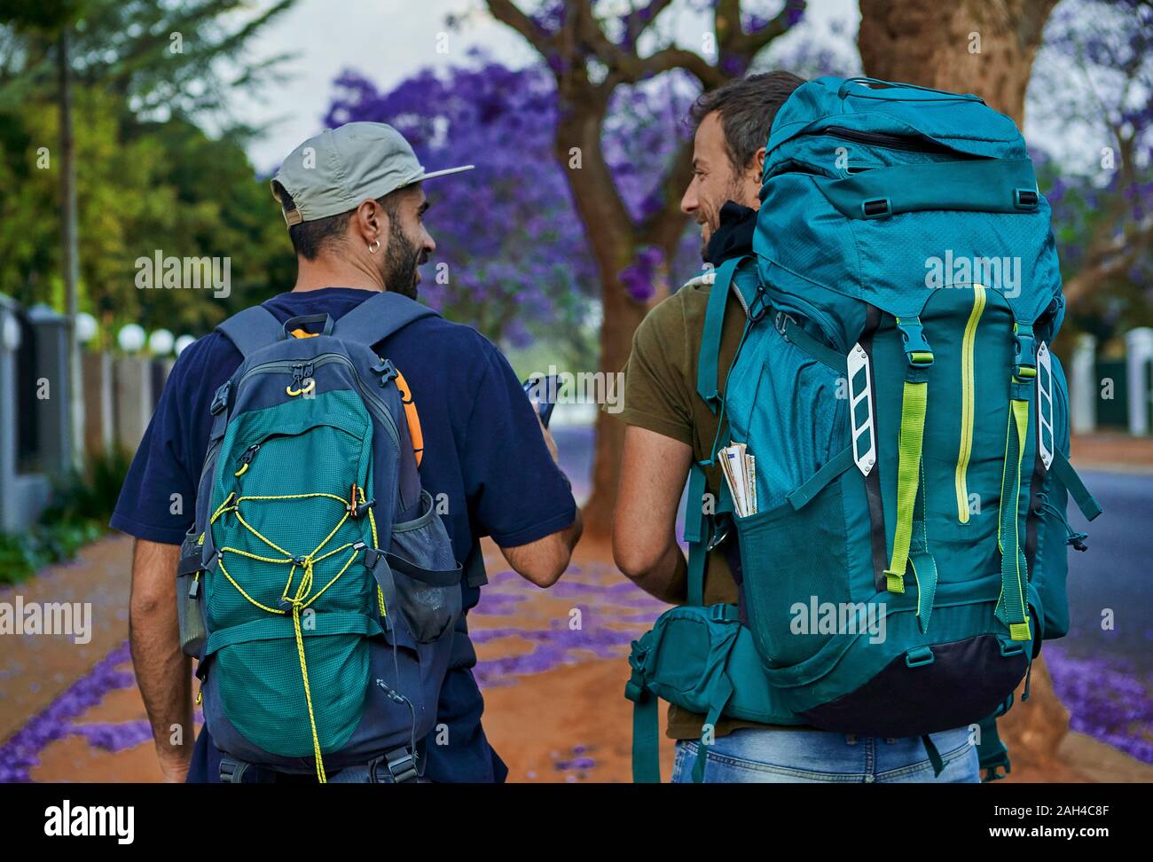 Two backpackers walking down a street Stock Photo - Alamy
