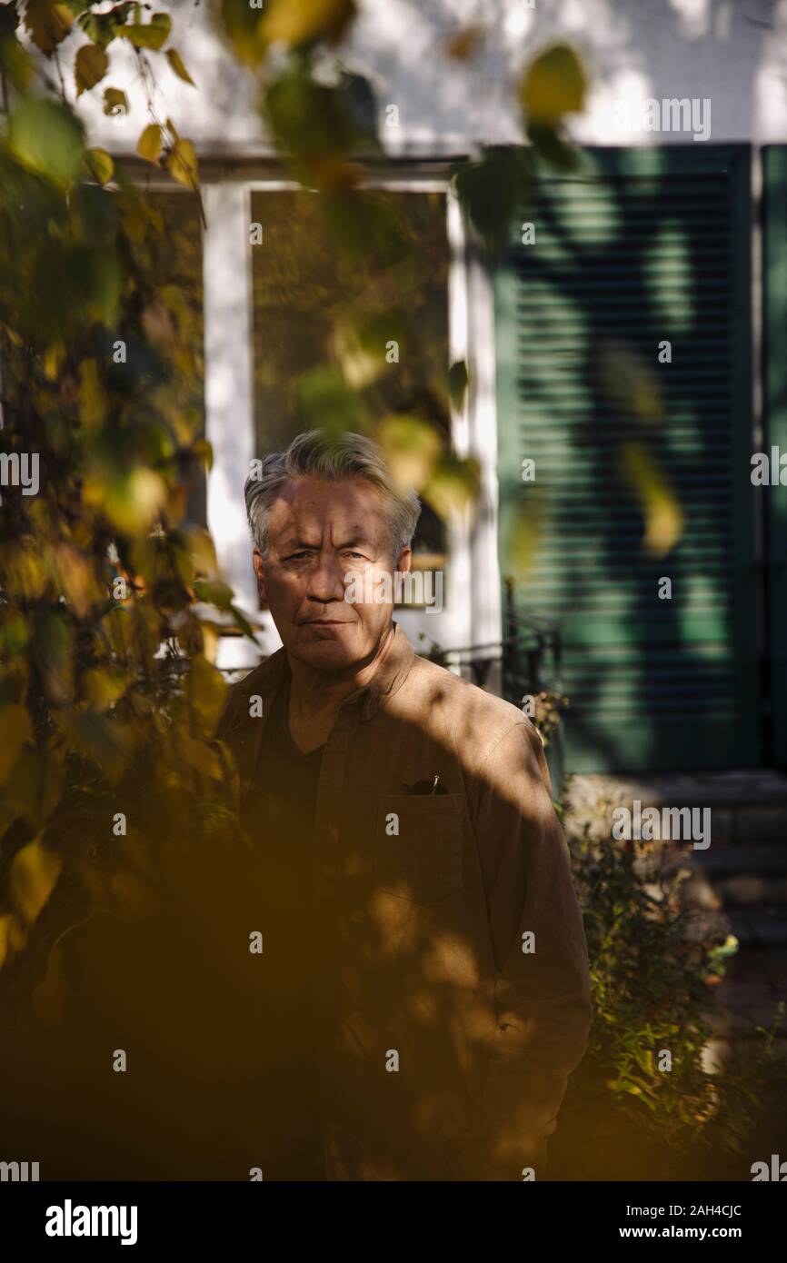 Portrait of a serious senior man at tree in garden Stock Photo - Alamy