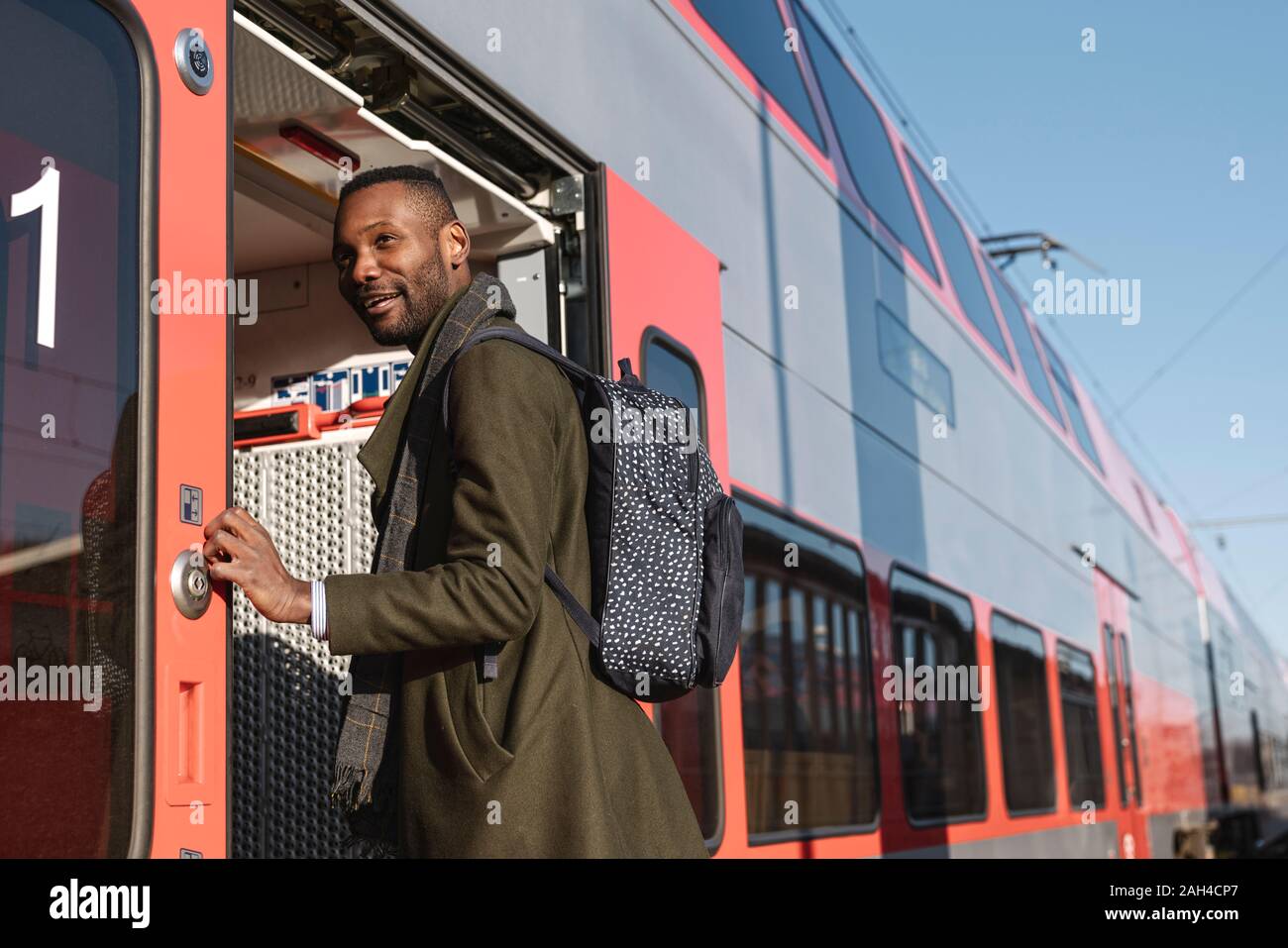 Portrait of stylish man entering a train Stock Photo - Alamy