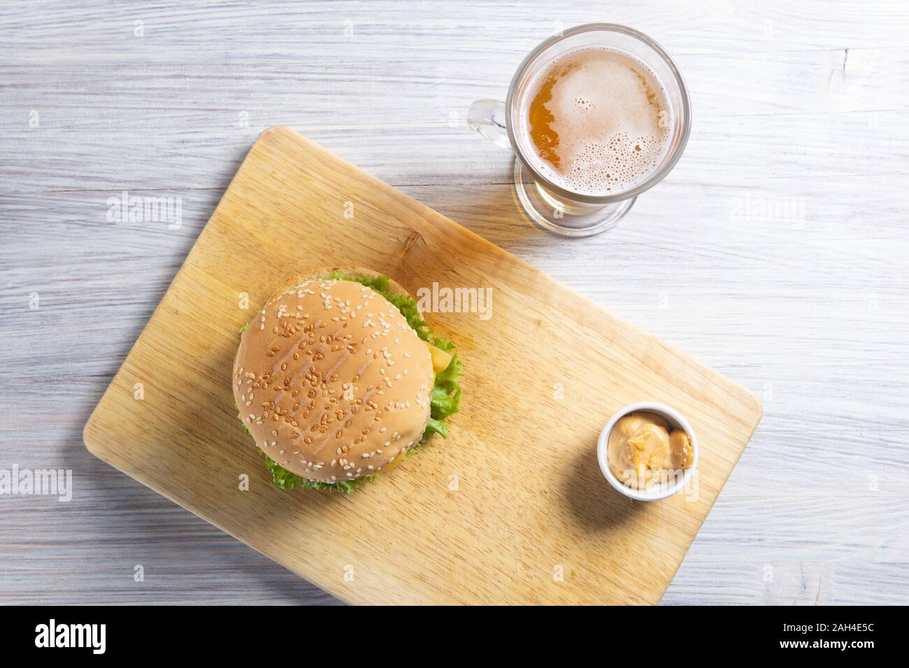 Burger with beef patty, salad, a slice of tomato and cheese, onions and ...