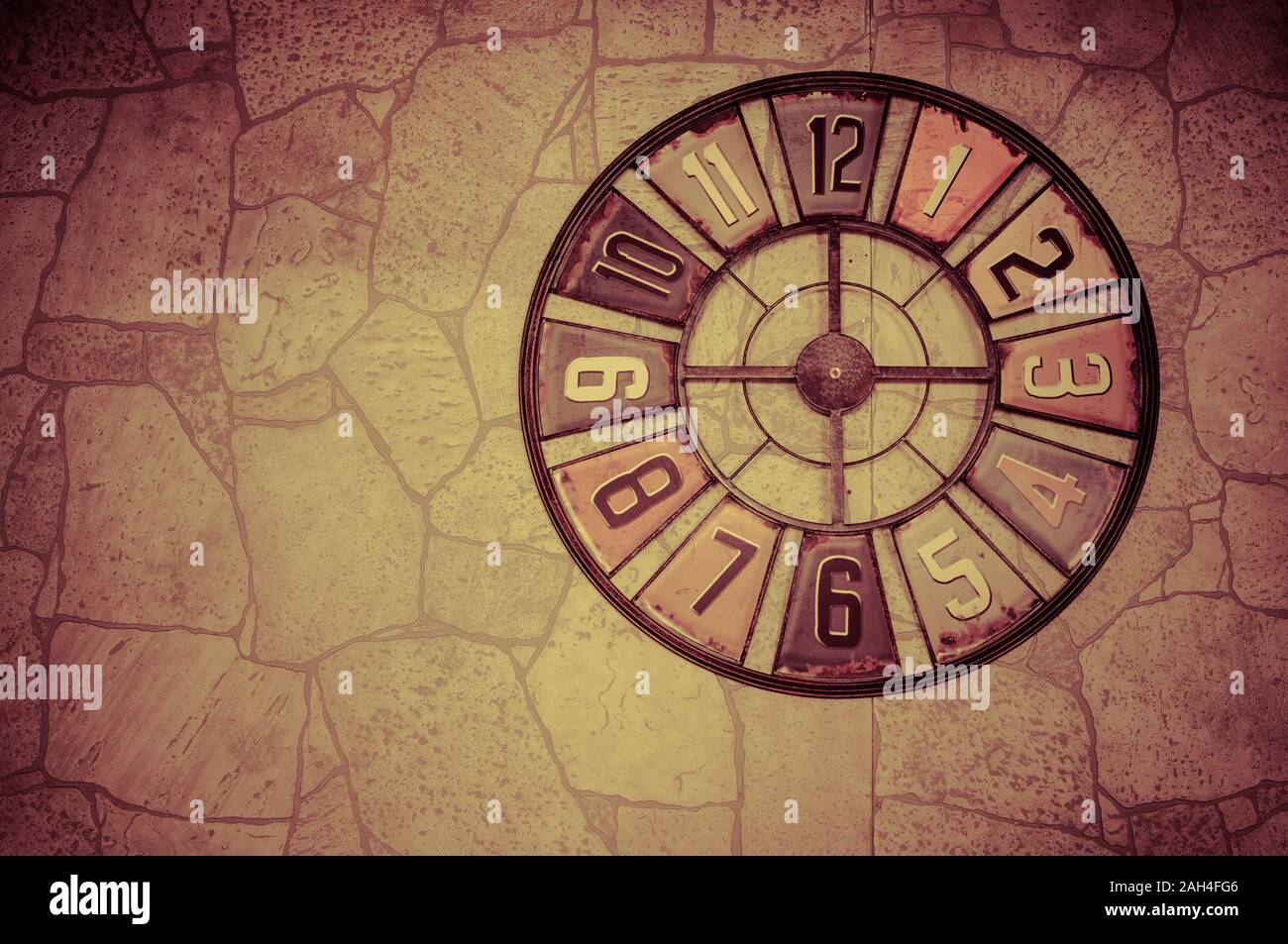 Beautiful symbolic clock on a wall with a stone texture. Toned photo ...