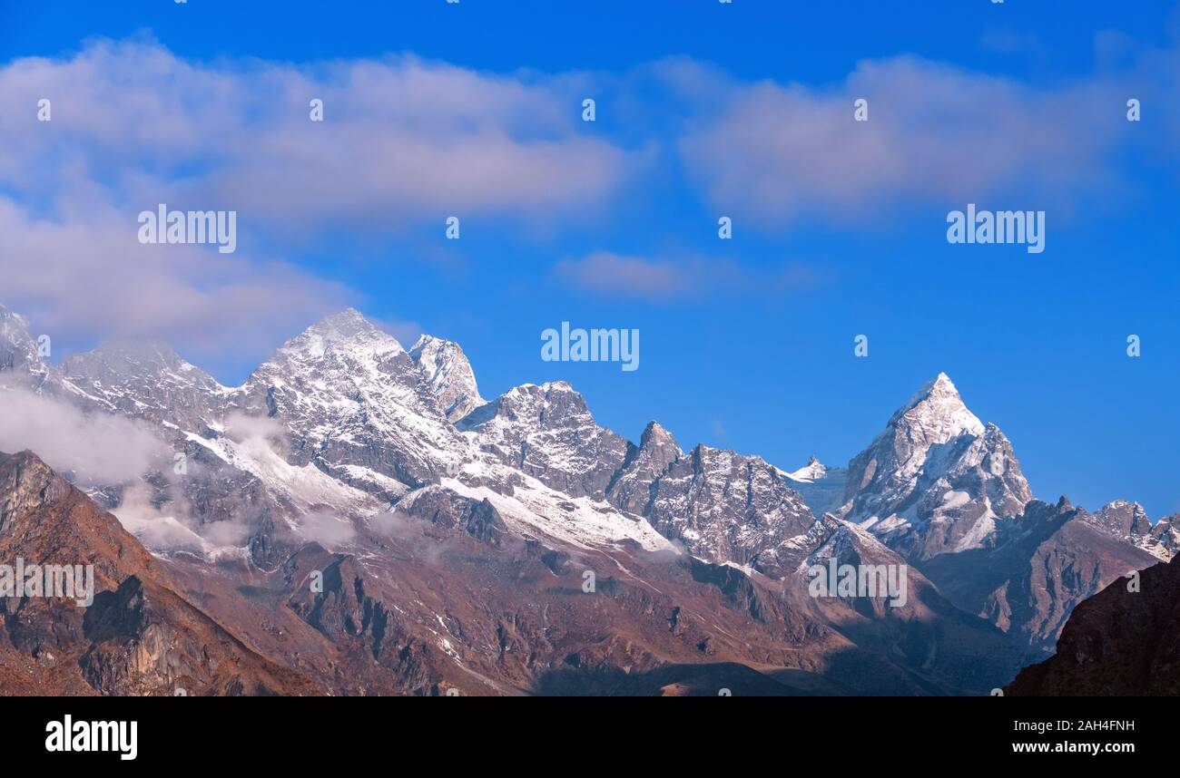 Majestic Himalayan peaks on the background of blue sky with clouds at ...