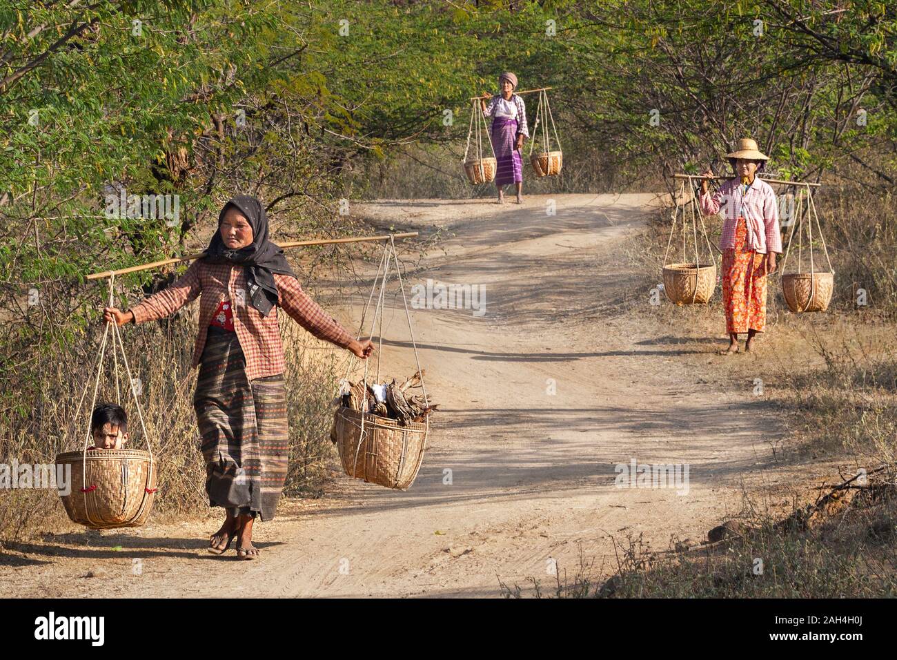 Women with their basket with one of them carrying her child and wood in ...