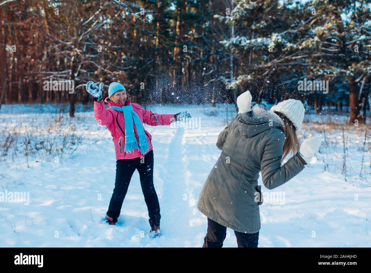 Snowballs playing in winter forest. Family mother and daughter having ...