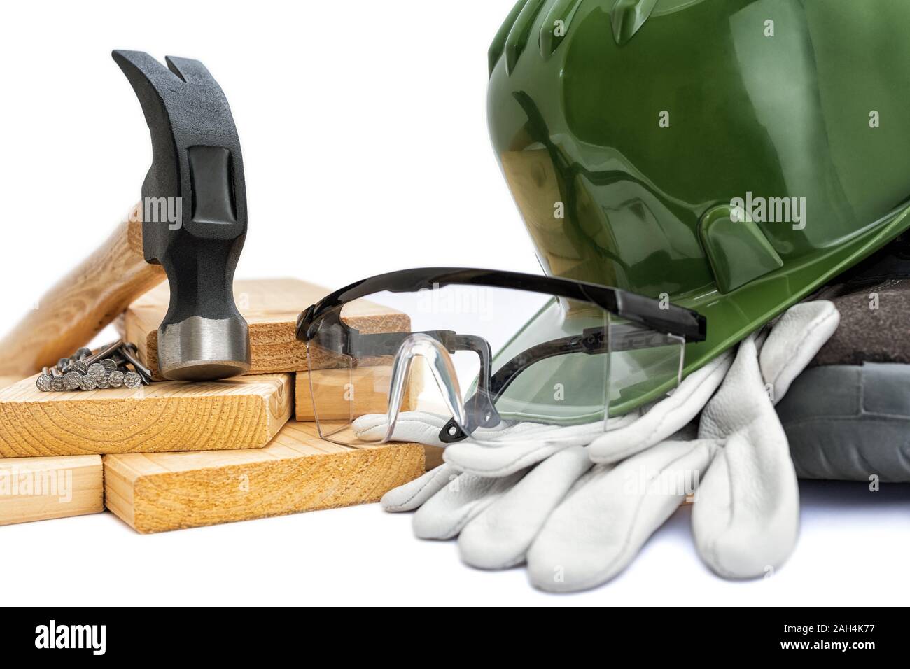 Close-up of a carpenter's hammer, helmet, goggles and protective gloves ...