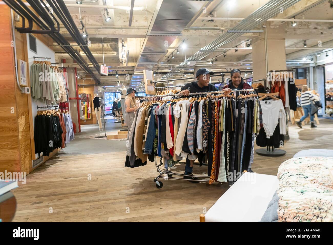 Workers move merchandise in an Urban Outfitters retail store in Herald ...