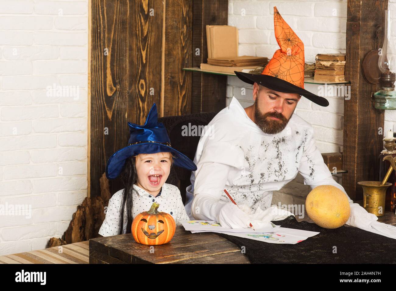 Witcher and little magician make decor for Halloween. Man and boy on ...