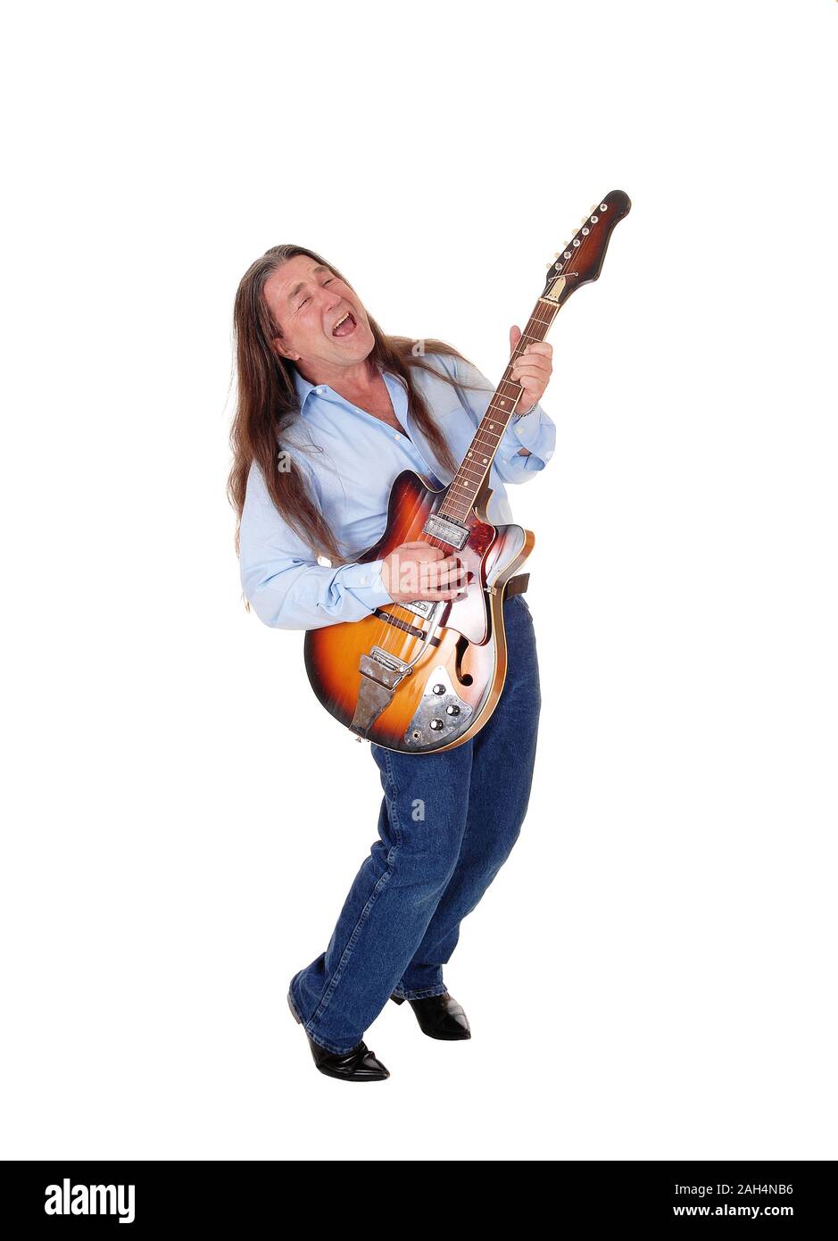 A happy musician playing his guitar with his long brunette hair ...