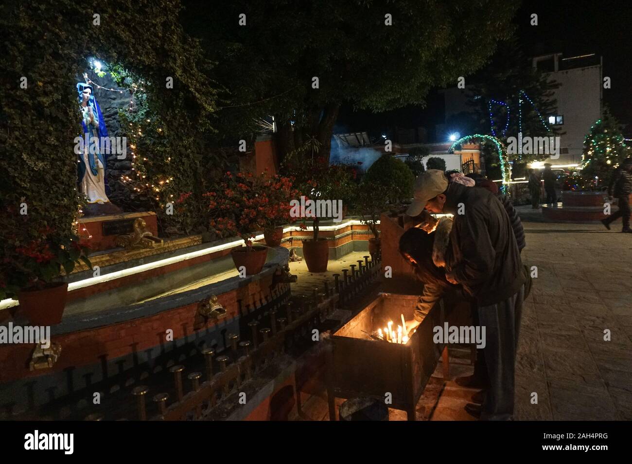People lighting candles during the Christmas Eve mass at the Catholic ...
