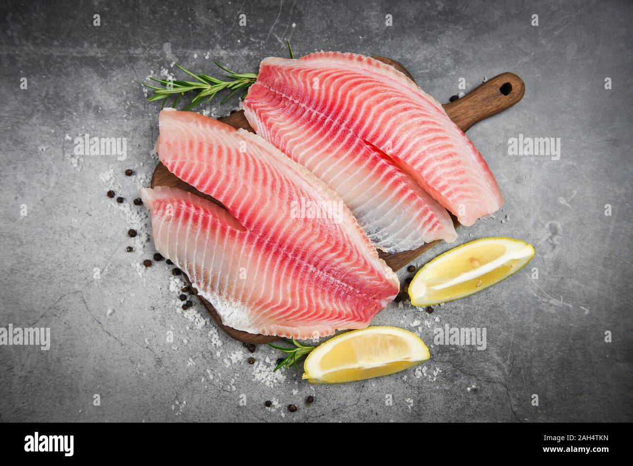 Fresh fish fillet sliced for steak or salad with herbs spices rosemary ...