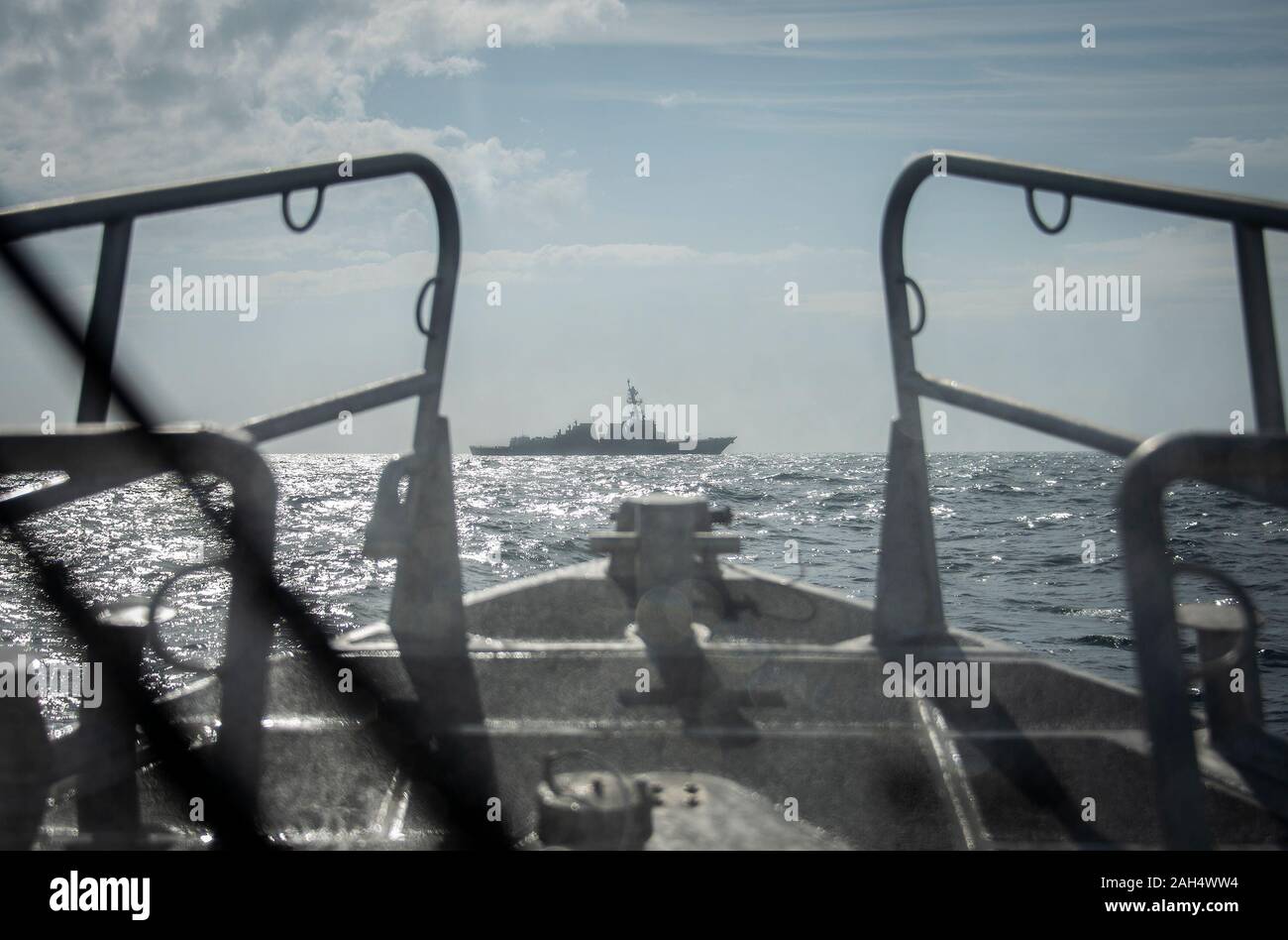 A 45-foot Coast Guard rescue boat moves toward the USS Thomas Hudner ...