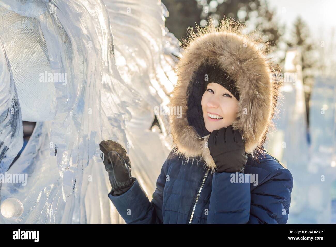 beautiful smiling young woman among the ice in wintertime outdoor ...