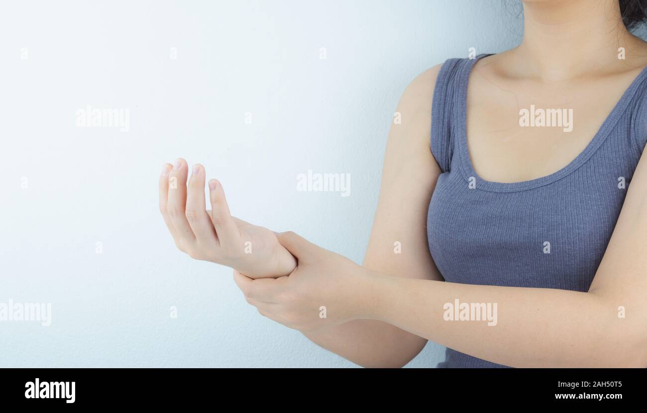 Closeup woman holds her wrist pain on white background. Health care and ...