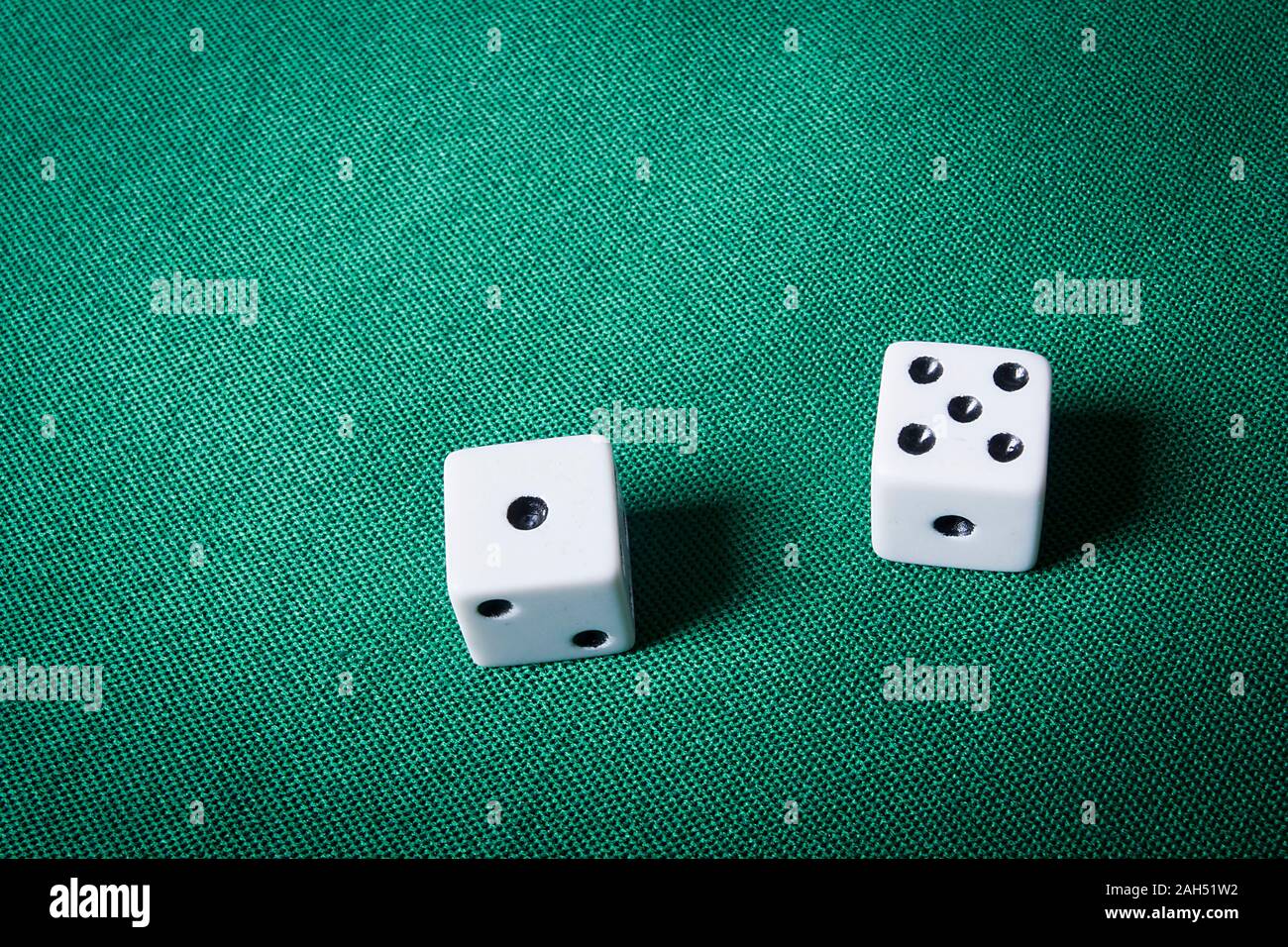 Dice on a table with green cloth Stock Photo - Alamy