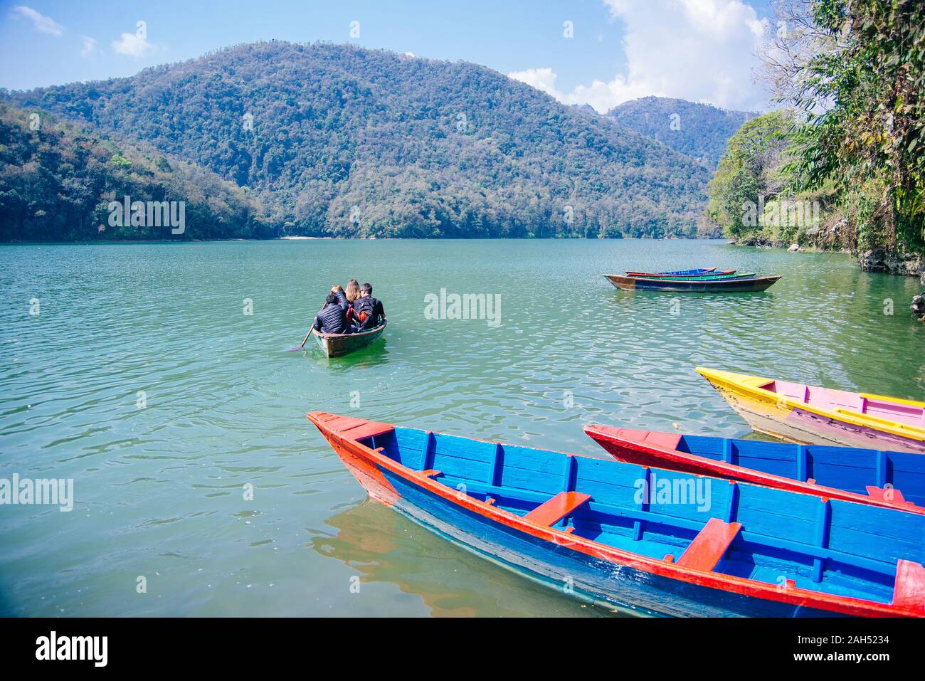 Phewa Lake with multicoloured boats in the valley of Pokhara in central ...