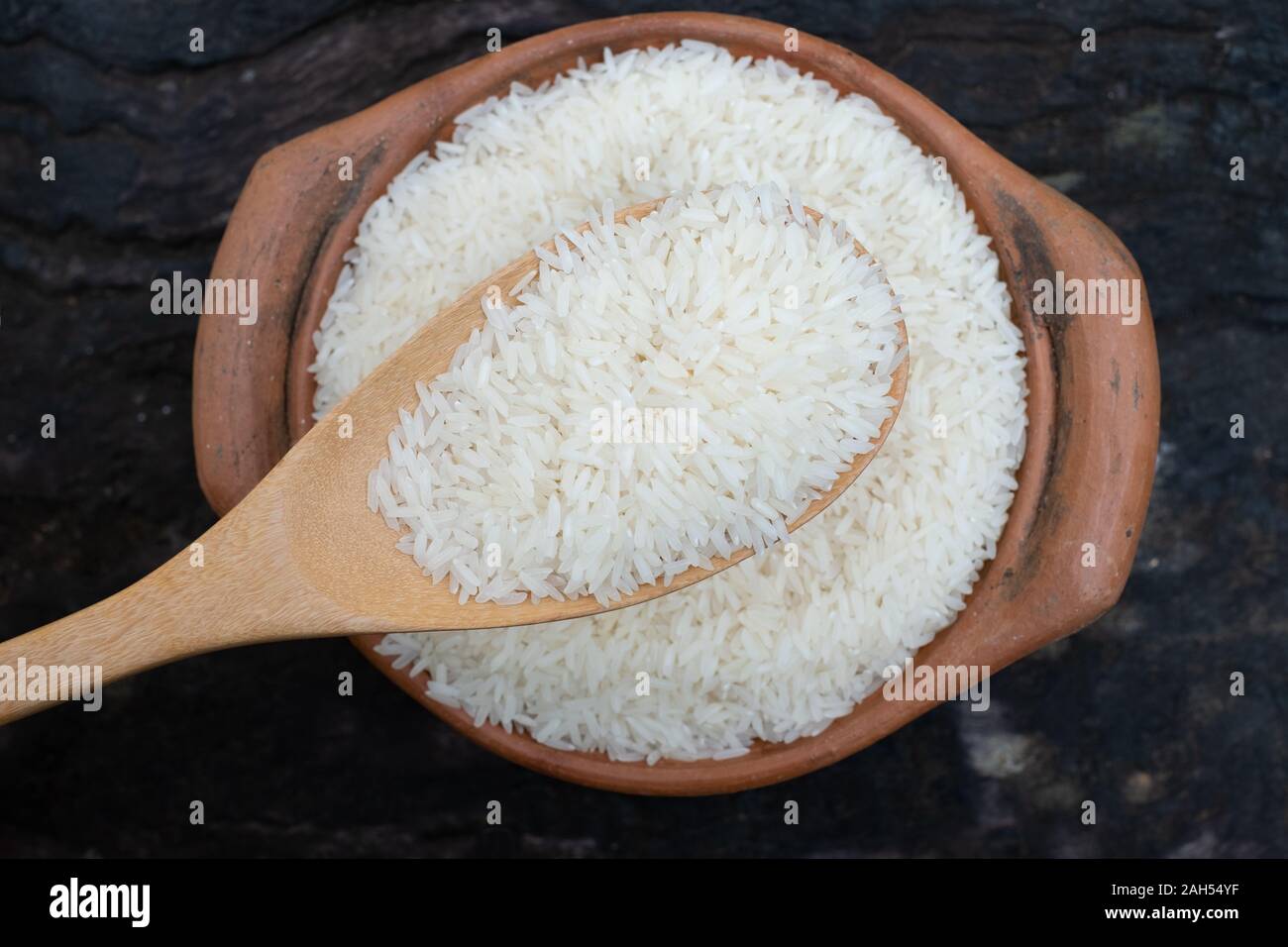 Scoop rice by using a ladle in a clay pot at the wood background Stock ...