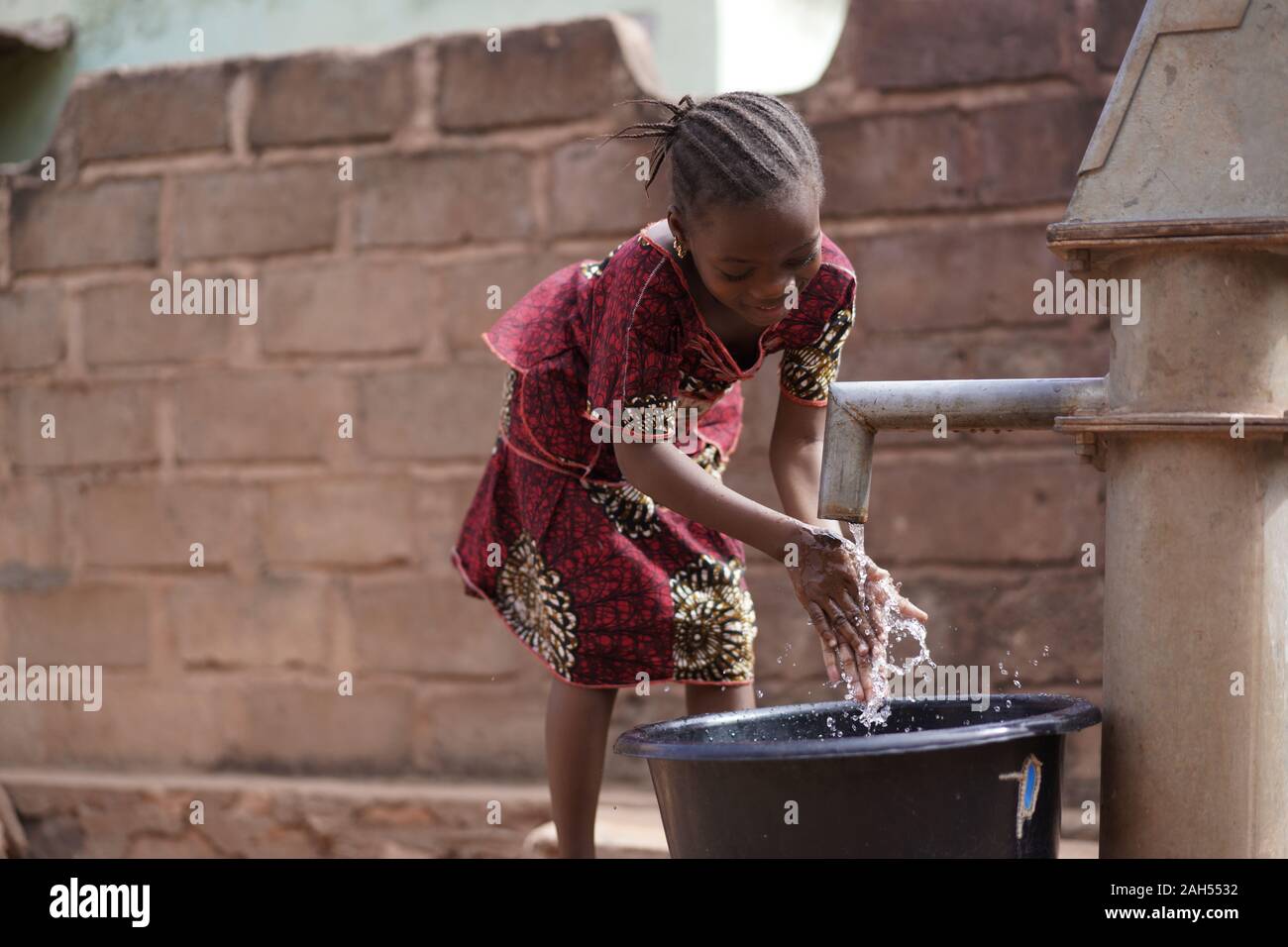 Small African Girl Washing Her Hands At The Village Well Stock Photo ...