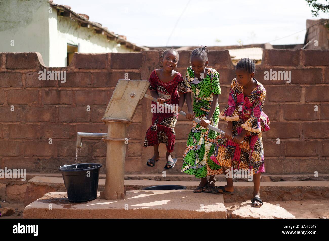Three Little African Girls Having Fun While Pumping Water At The ...