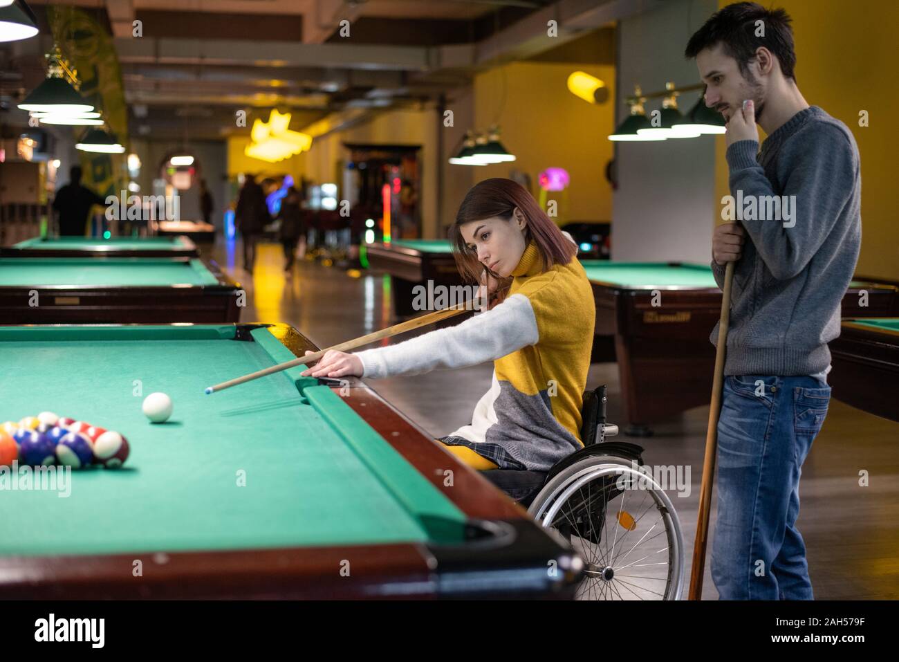 Beautiful disabled girl in a wheelchair playing billiards with her ...