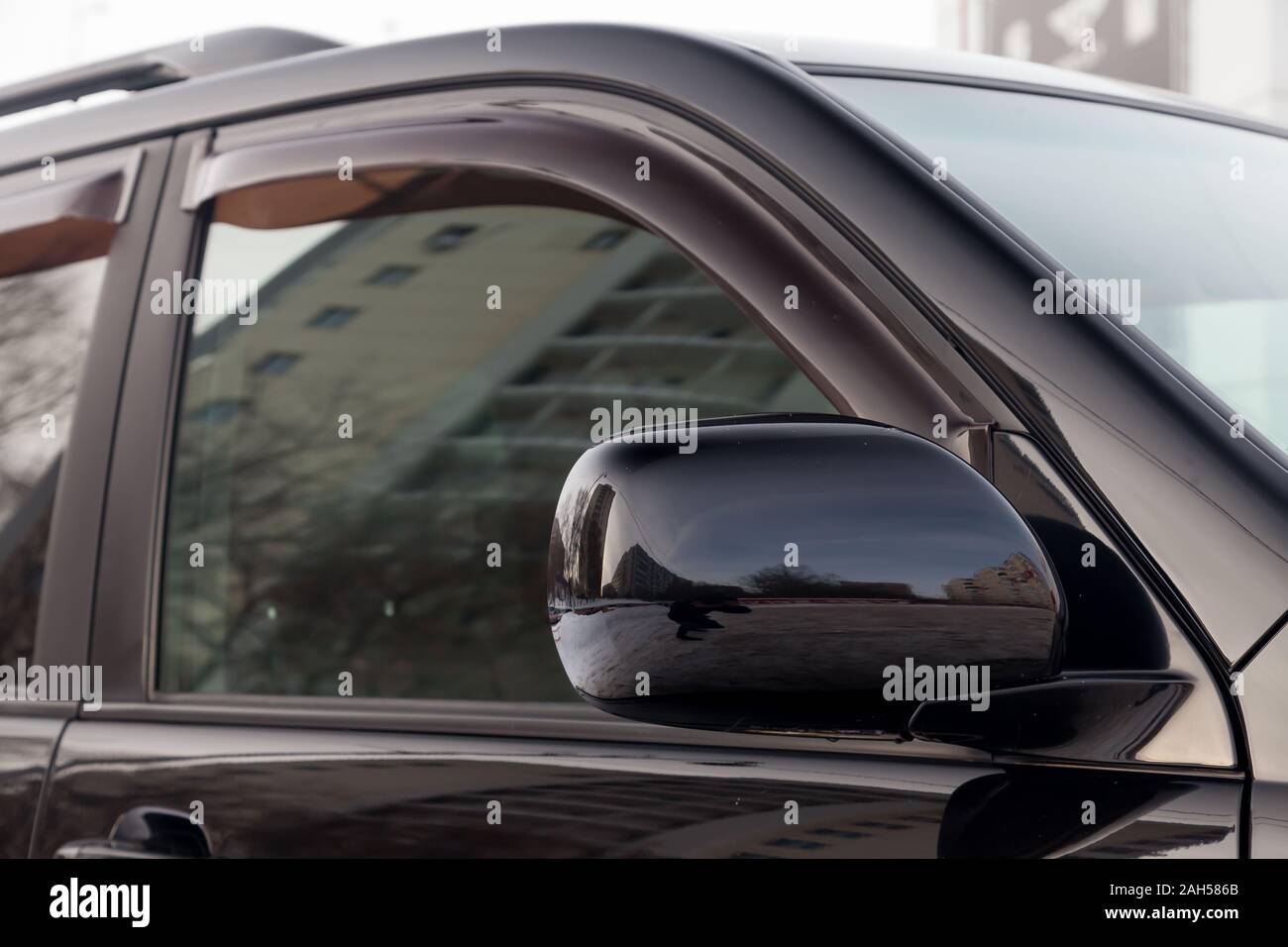 Close-up of the side left mirror and window of the car body black SUV ...