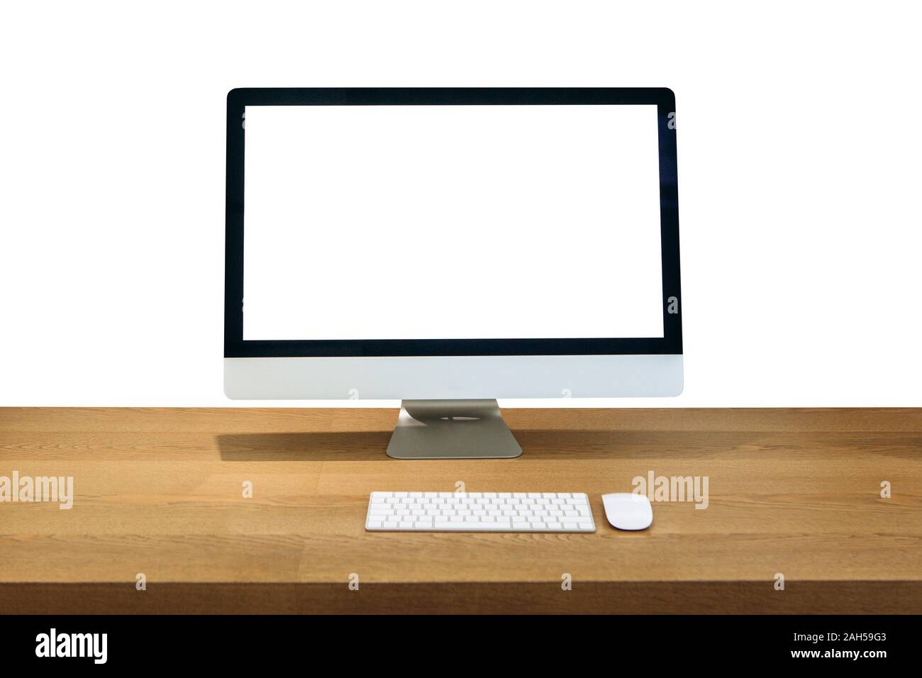 Modern personal computer on a wooden table with a white white screen ...