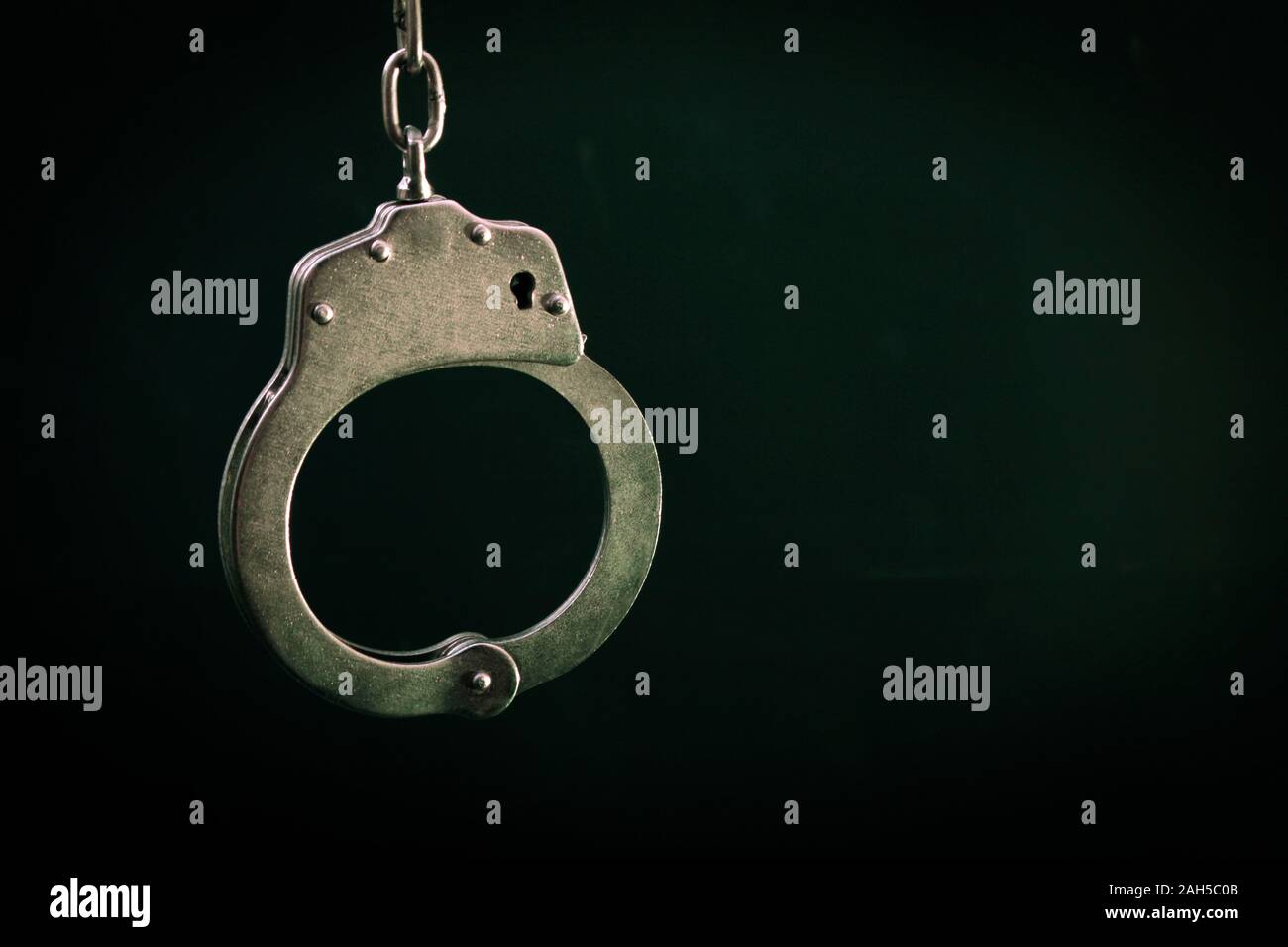 handcuff on dark background Stock Photo - Alamy