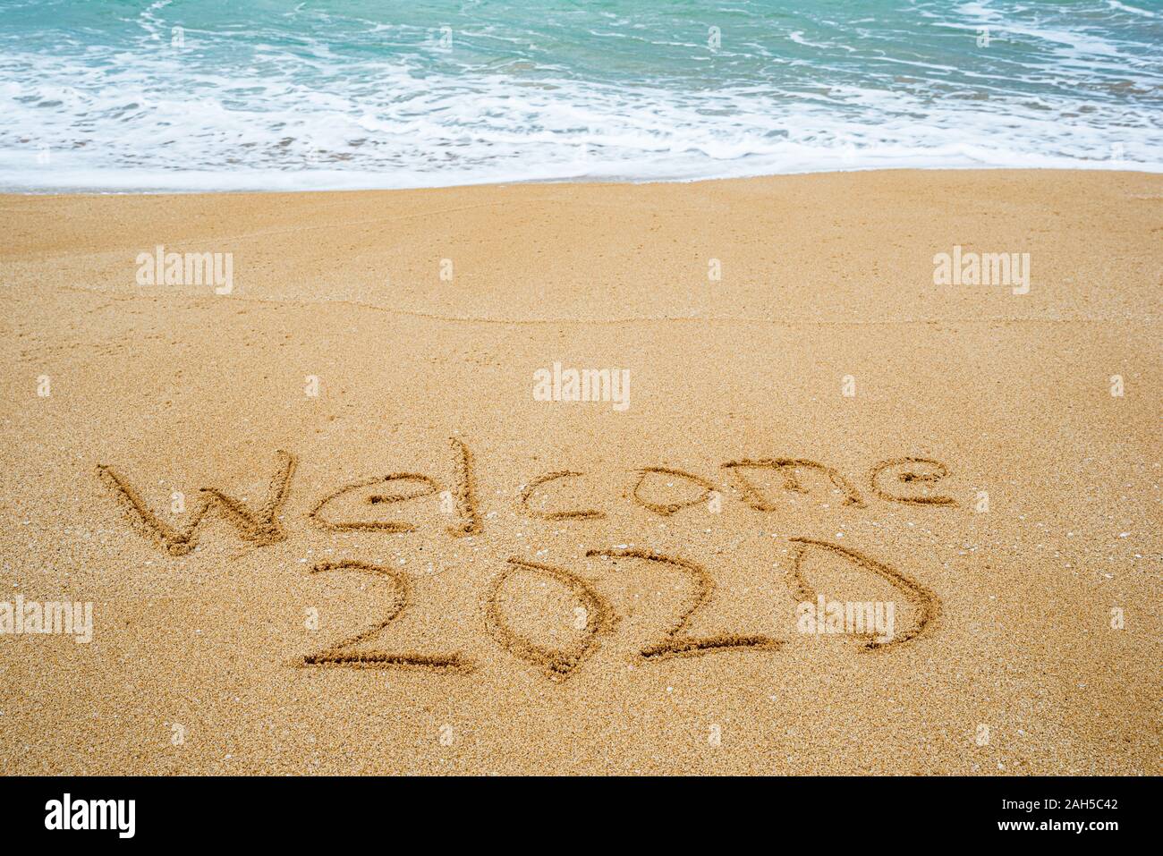 Welcome 2020 written in the sand- New Year concept Stock Photo - Alamy
