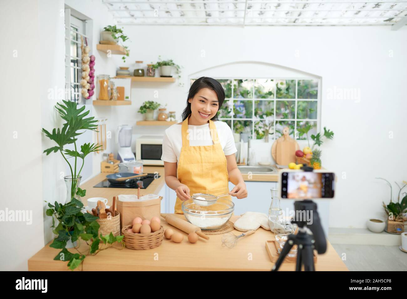 Pretty young asian female food blogger working on a new video and ...