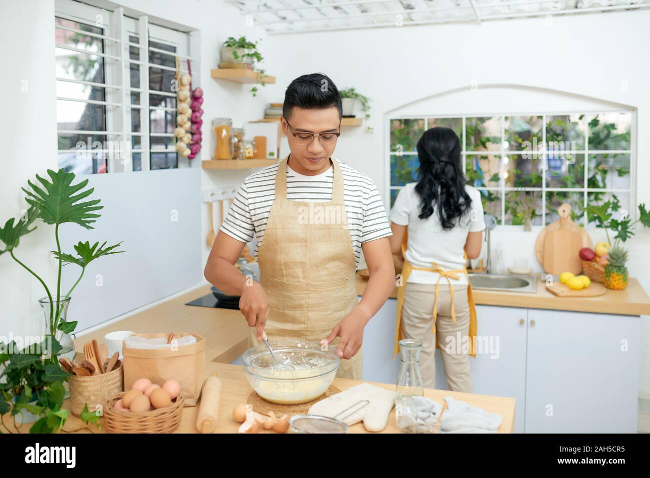 Couple cooking bakery in kitchen room, Young asian man and woman ...
