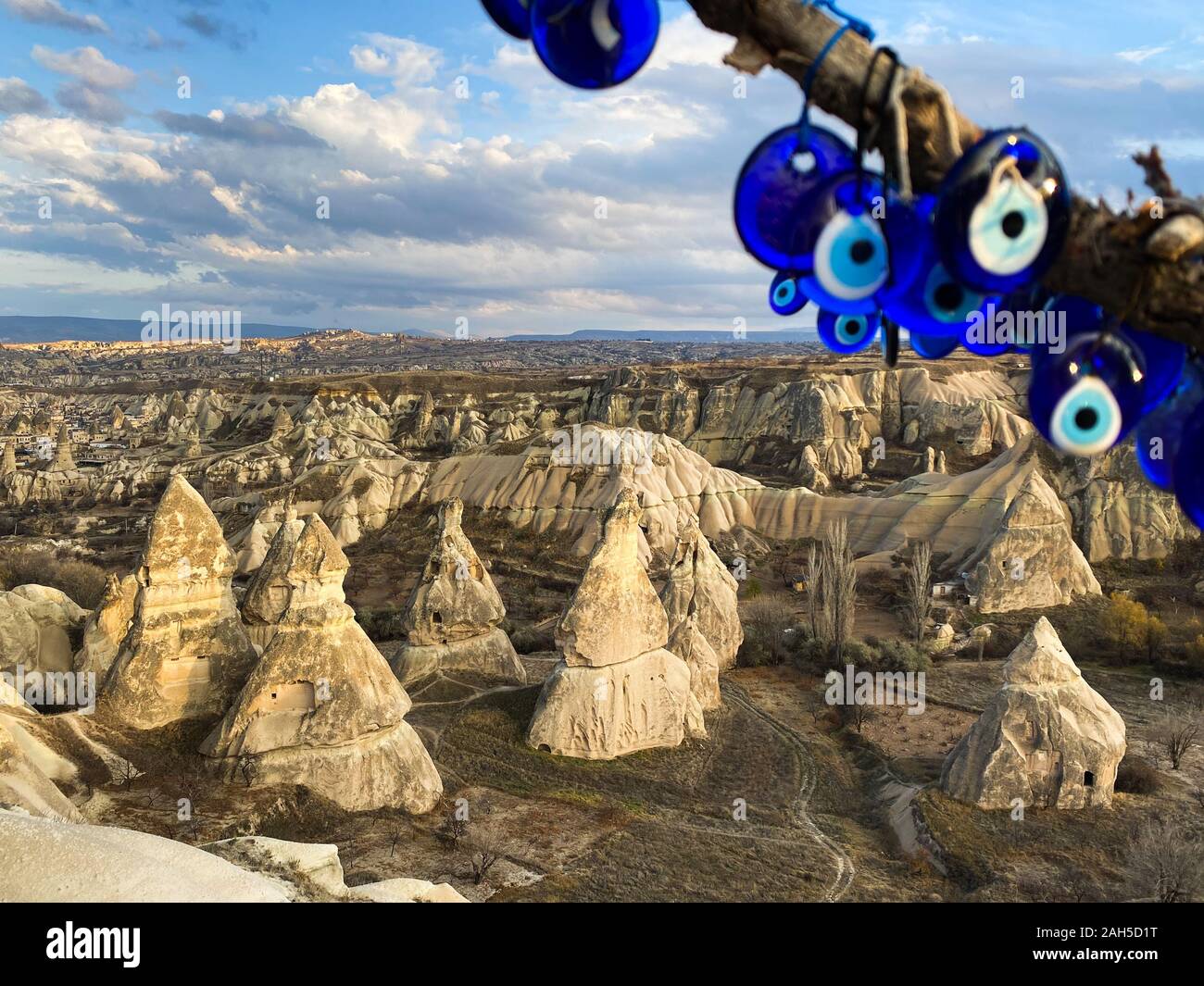Nazar amulets hang on a tree against a background of a valley of rocks ...