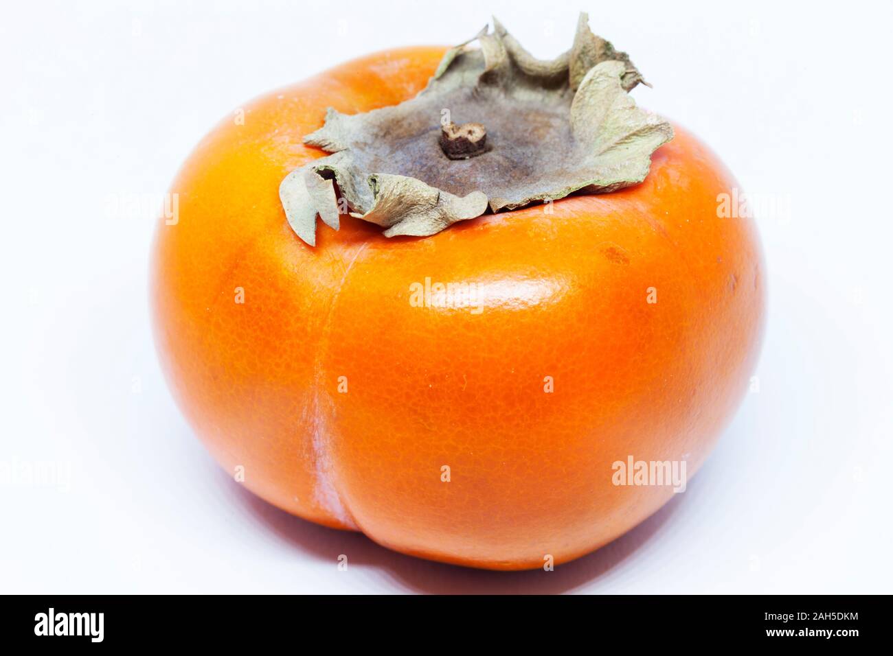 a whole sharon fruit on white background Stock Photo - Alamy