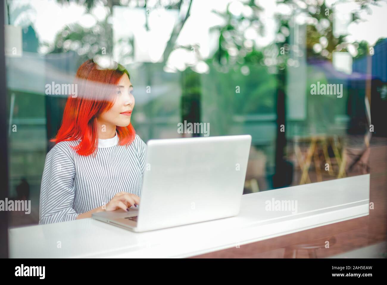 Pretty girl student study with personal laptop computer near window. A ...