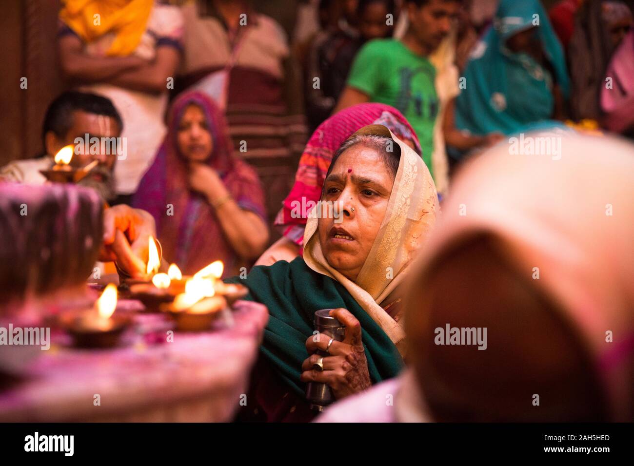 Woman lighting a candle while attending Holi celebrations inside Bankey ...