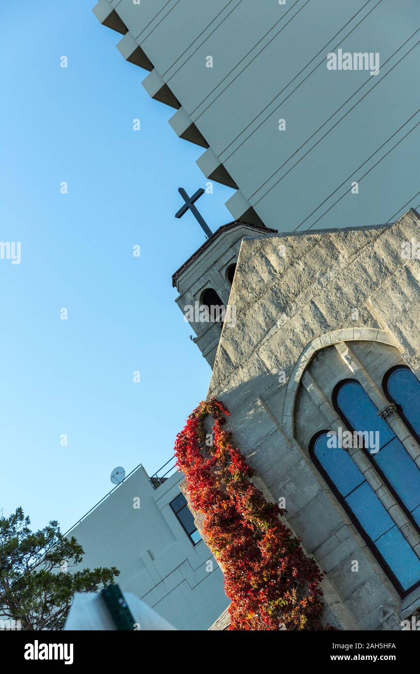 Diagonal view of a church building and spire with a cross topper Stock ...