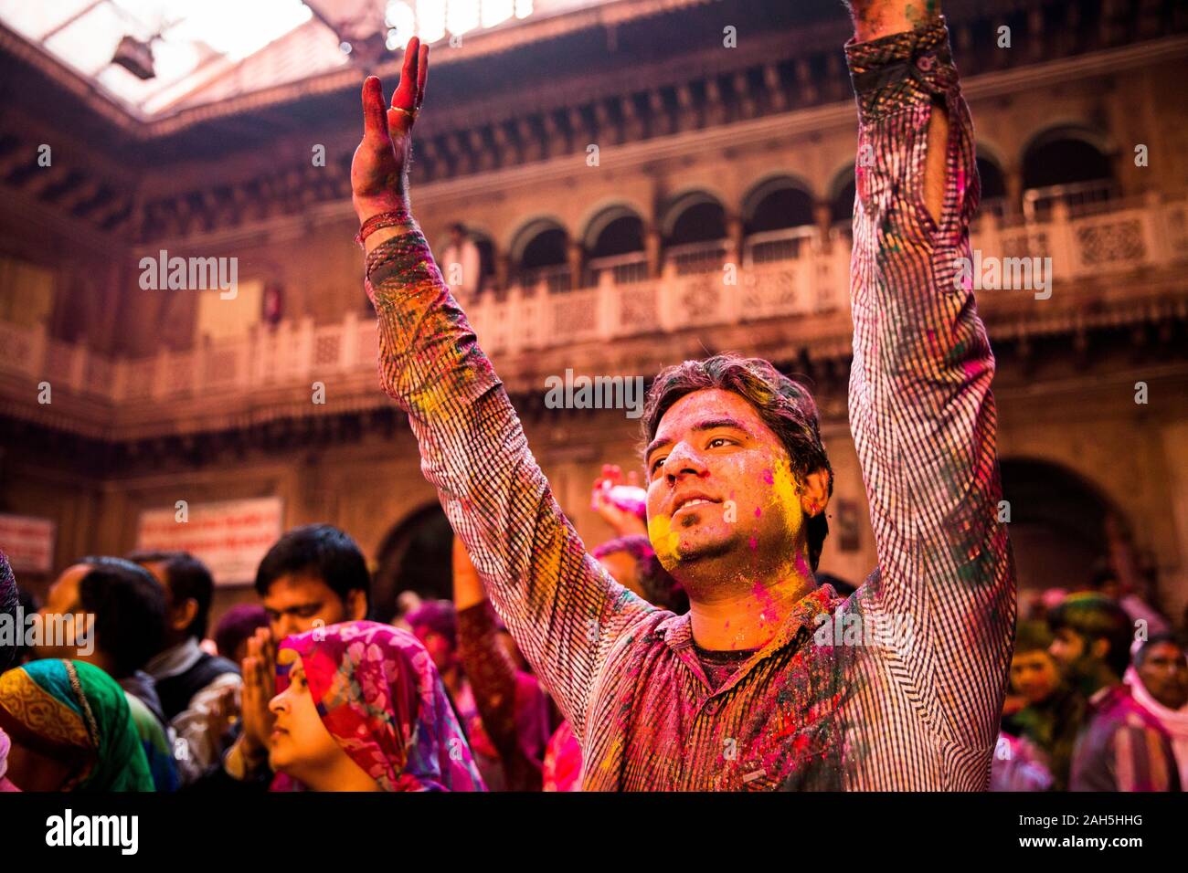 Man raising his arms in devotion during Holi celebrations inside Bankey ...