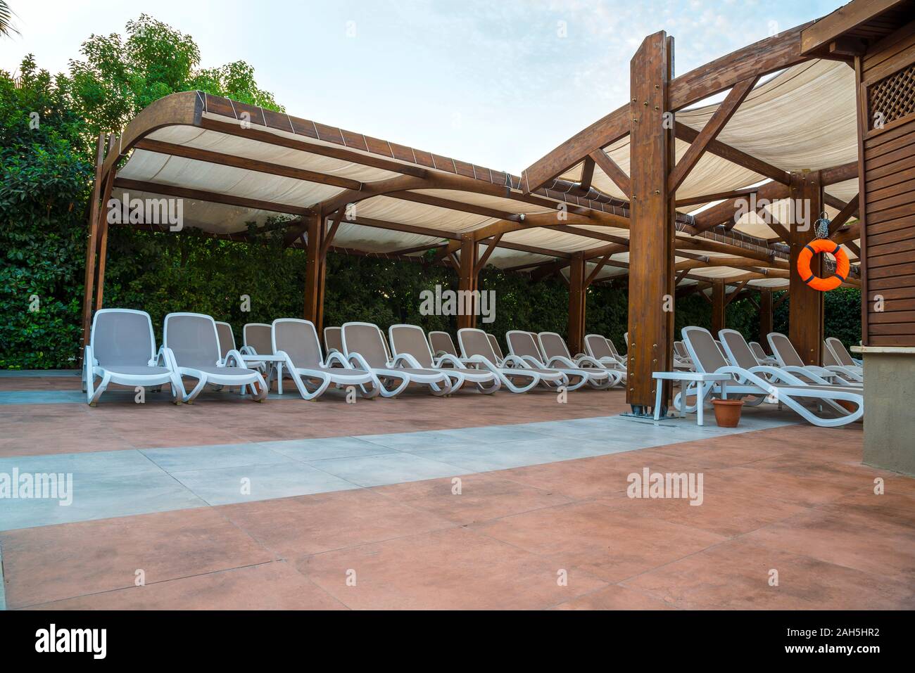 Empty stretchers by the pool in the summer resort Stock Photo - Alamy