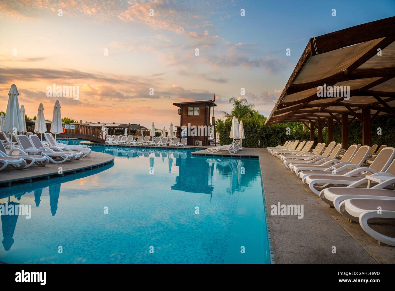 Empty stretchers by the pool in the summer resort Stock Photo - Alamy